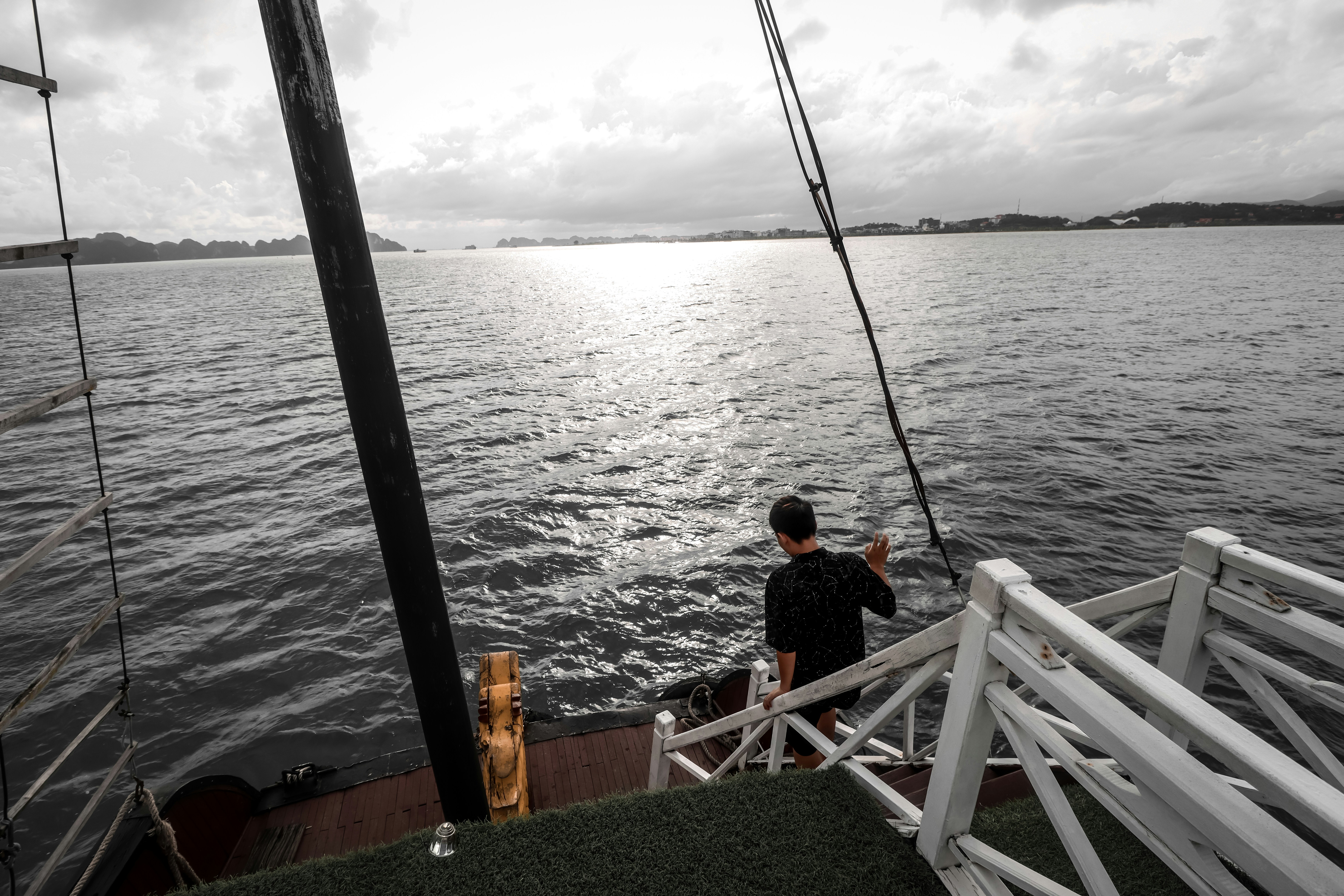 Bowside Frame: A Solitary Figure Gazes Toward the Silvery Horizon