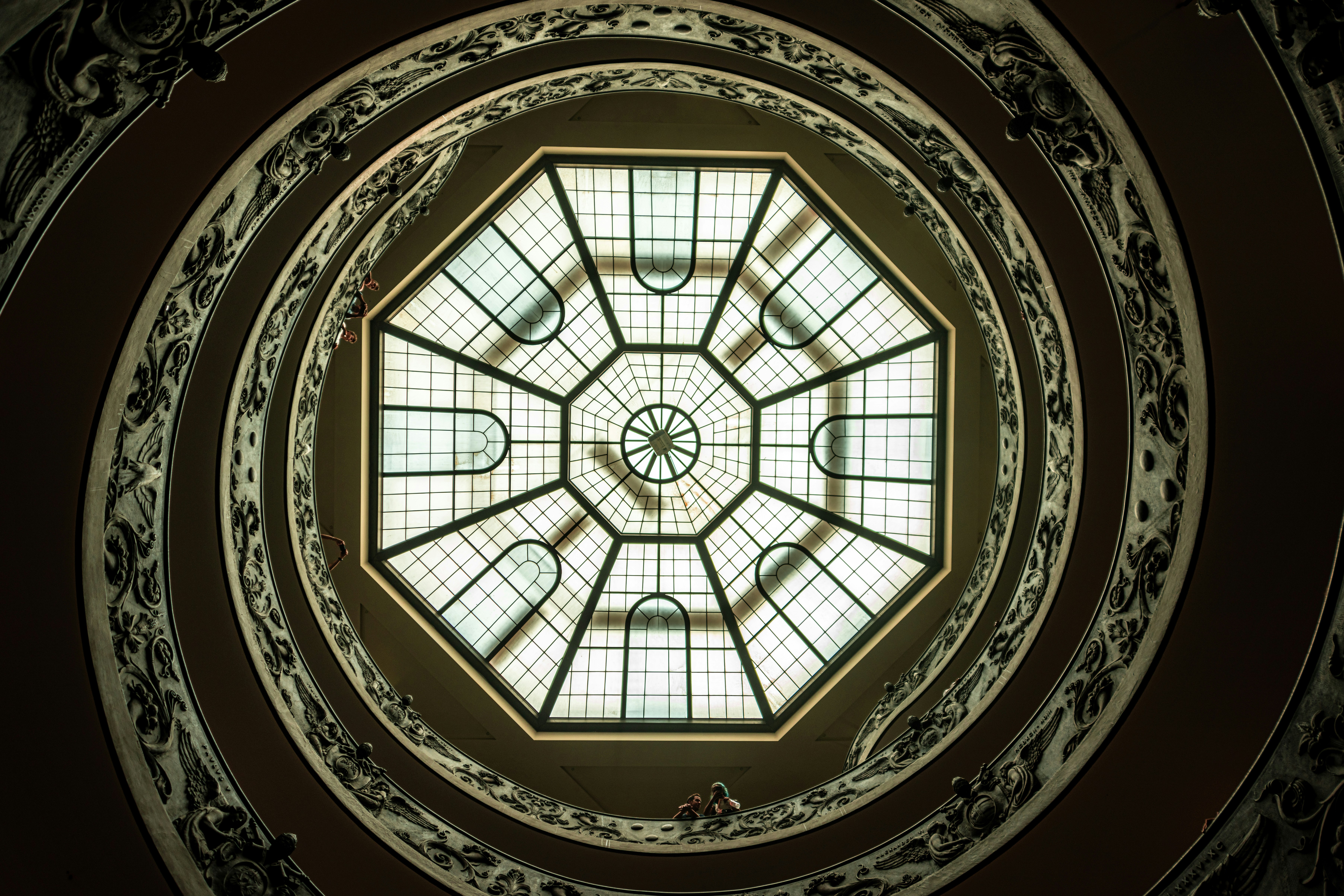 Intricate spiral staircase viewed from below, showcasing a stunning octagonal skylight adorned with ornate details.