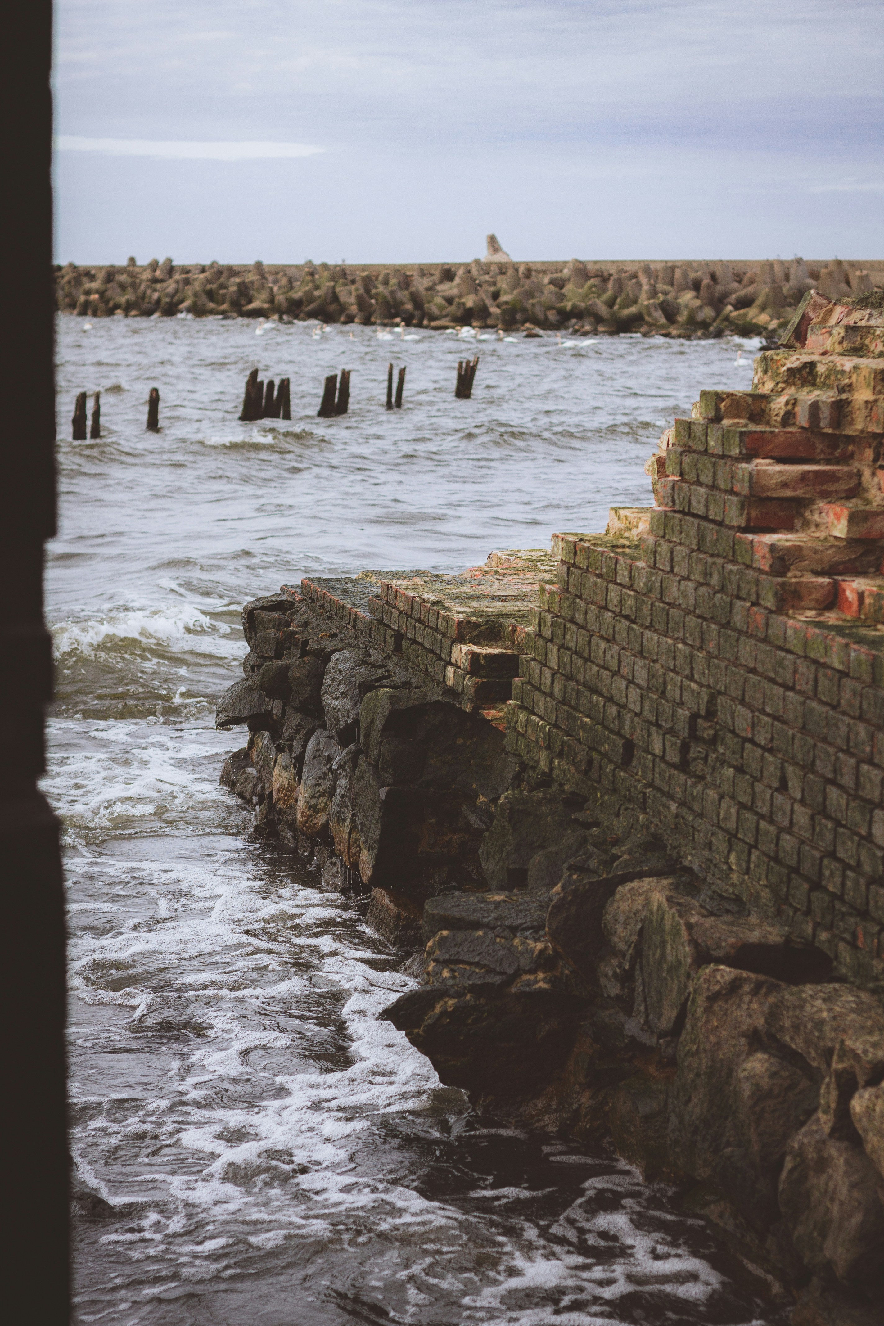 A stone wall with a stone wall and a body of water photo – Free Vistula ...