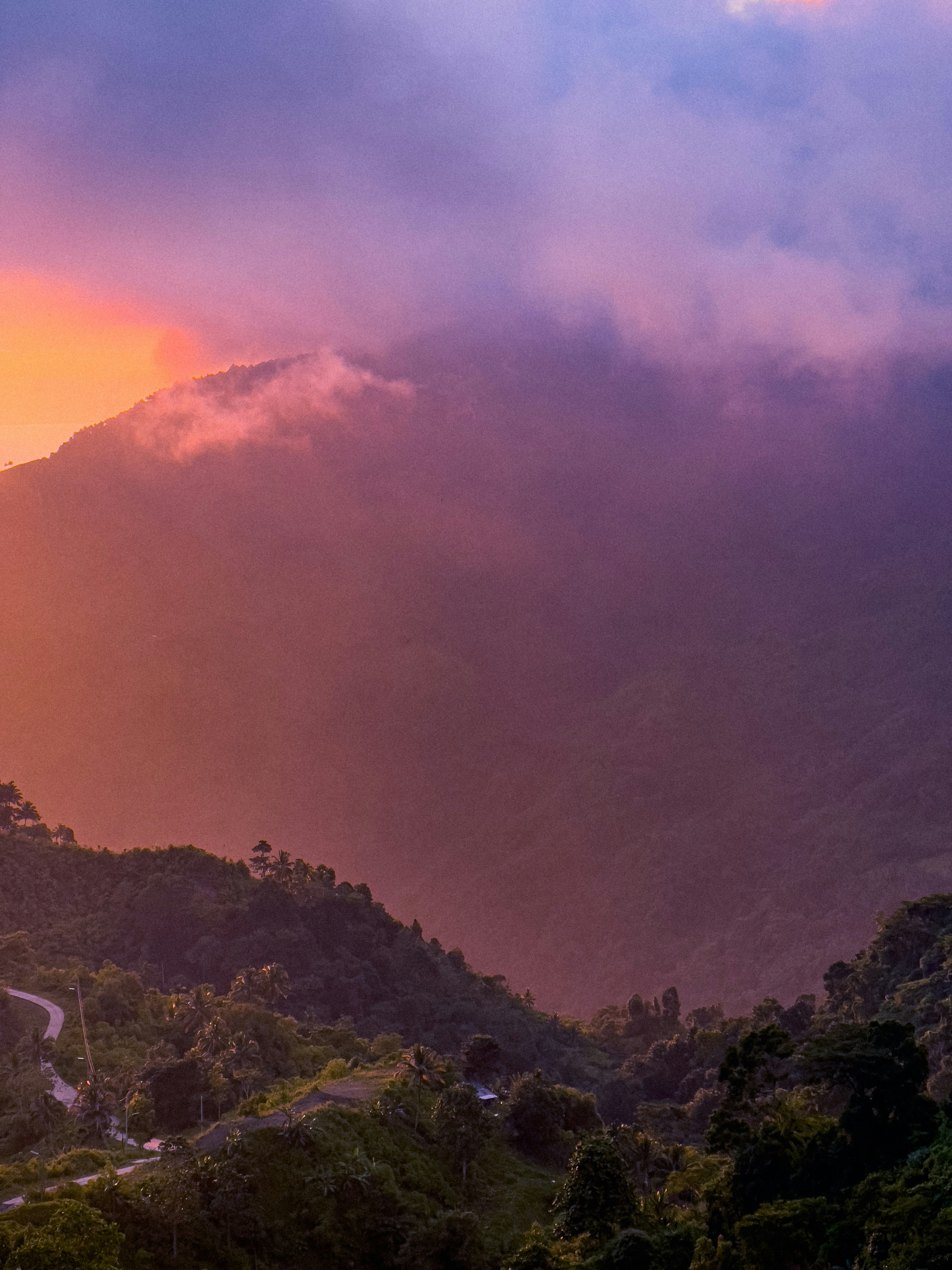 Ridge at Dusk: Orange Glow Drapes a Winding Valley Road