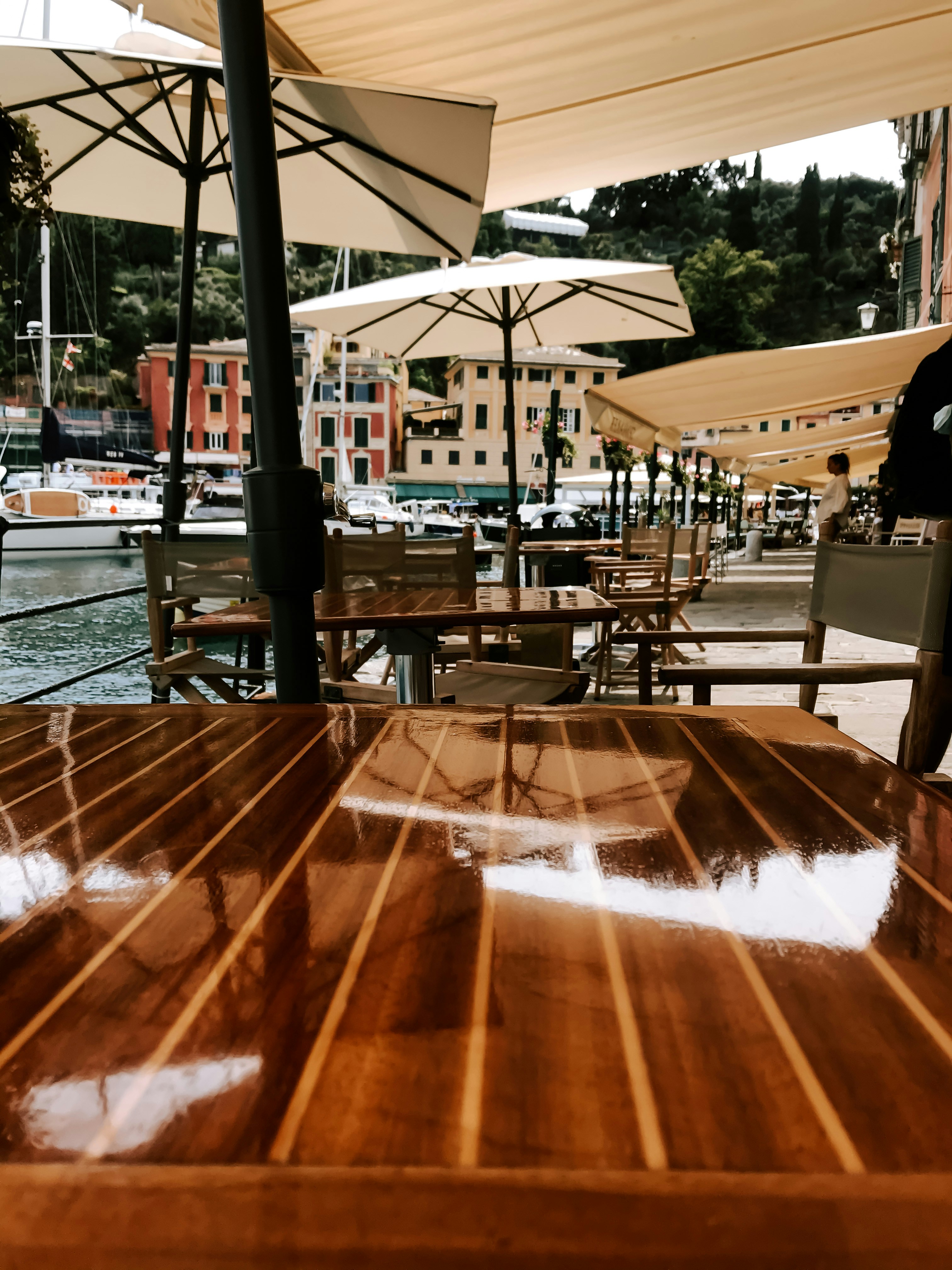 Sunlit Waterfront Café in a European Harbor