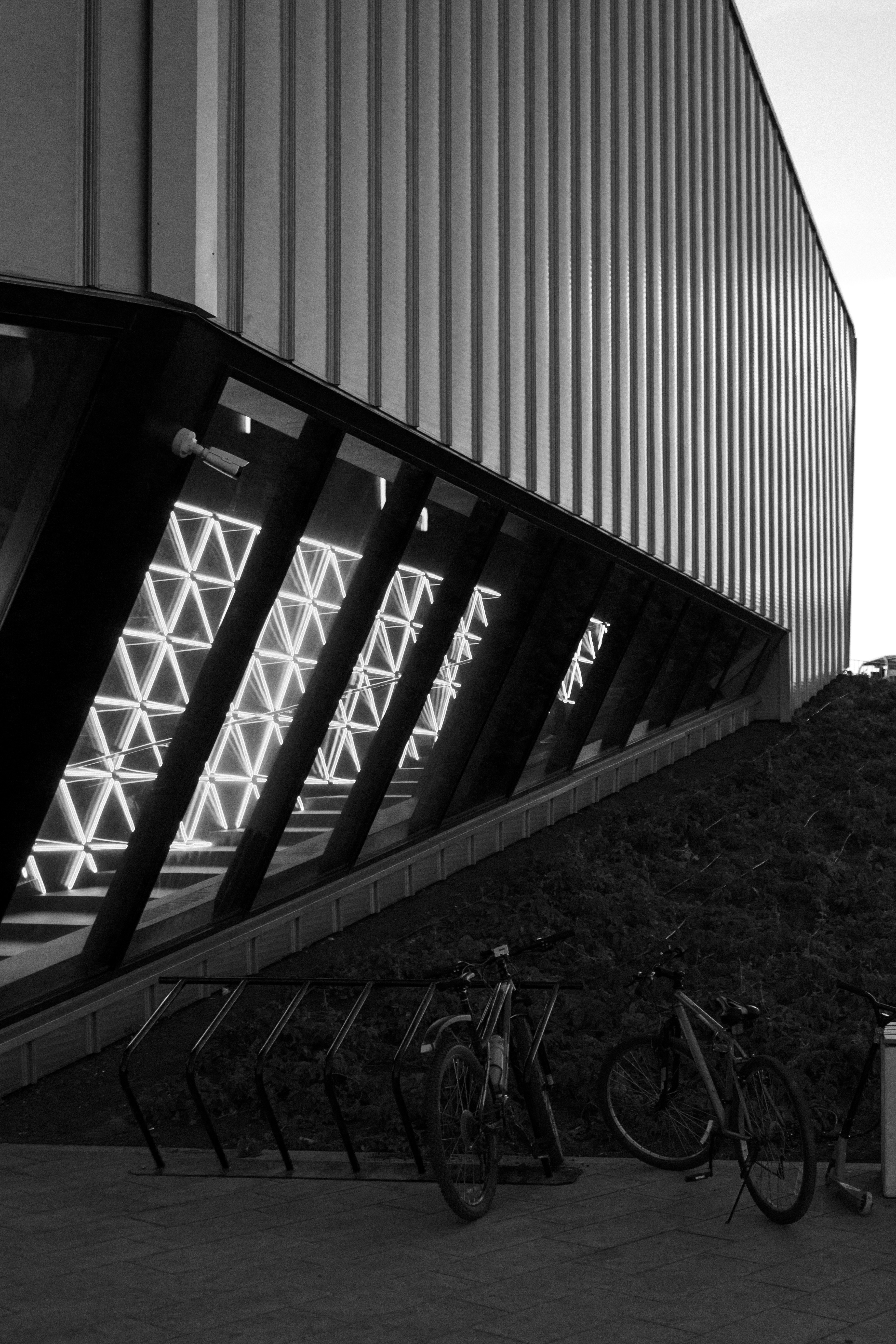 Angular Facade and Neon Triangles: A Quiet Street at Dusk