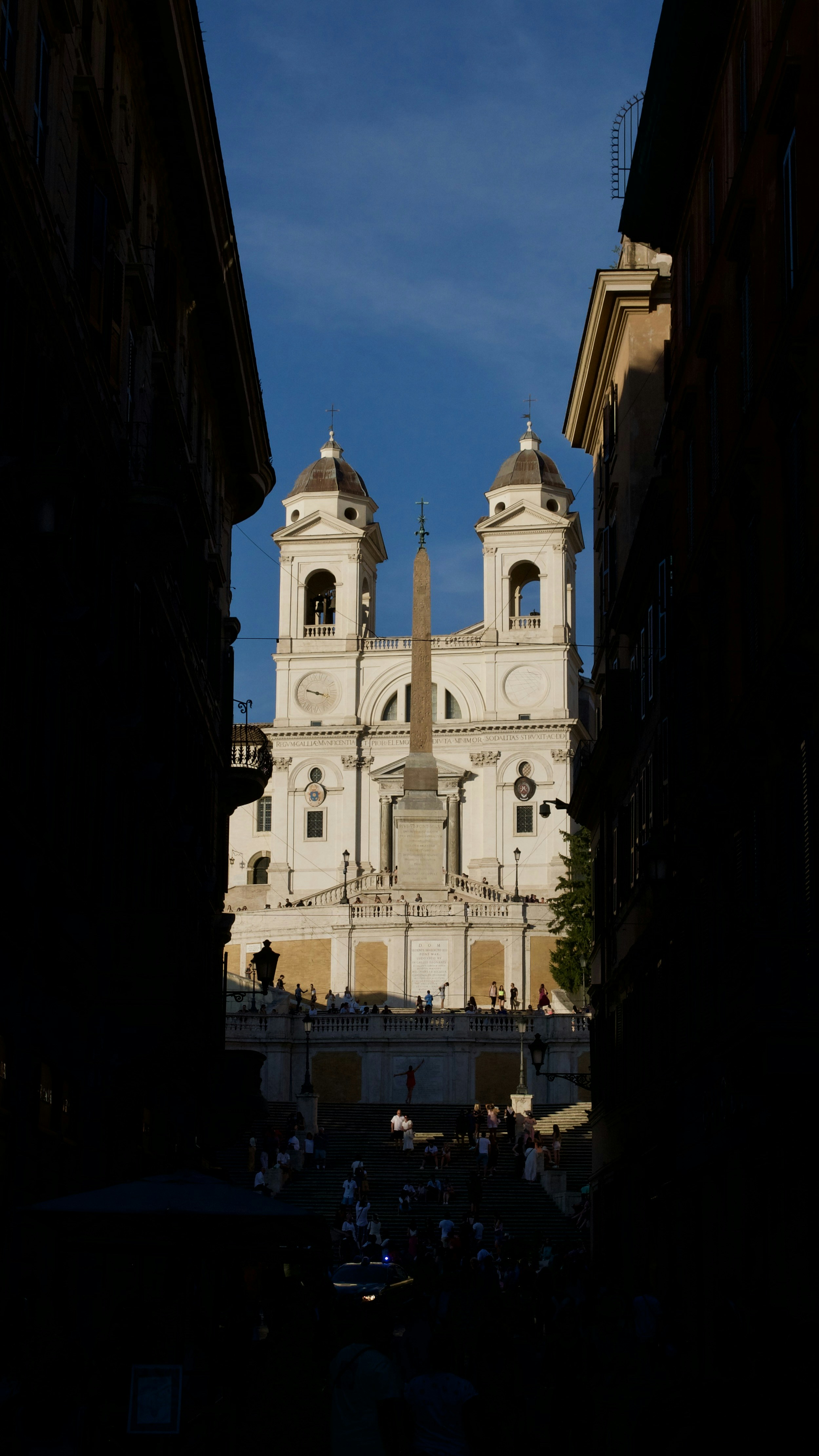 Sunlit Trinità dei Monti at the End of a Shadowed Roman Street