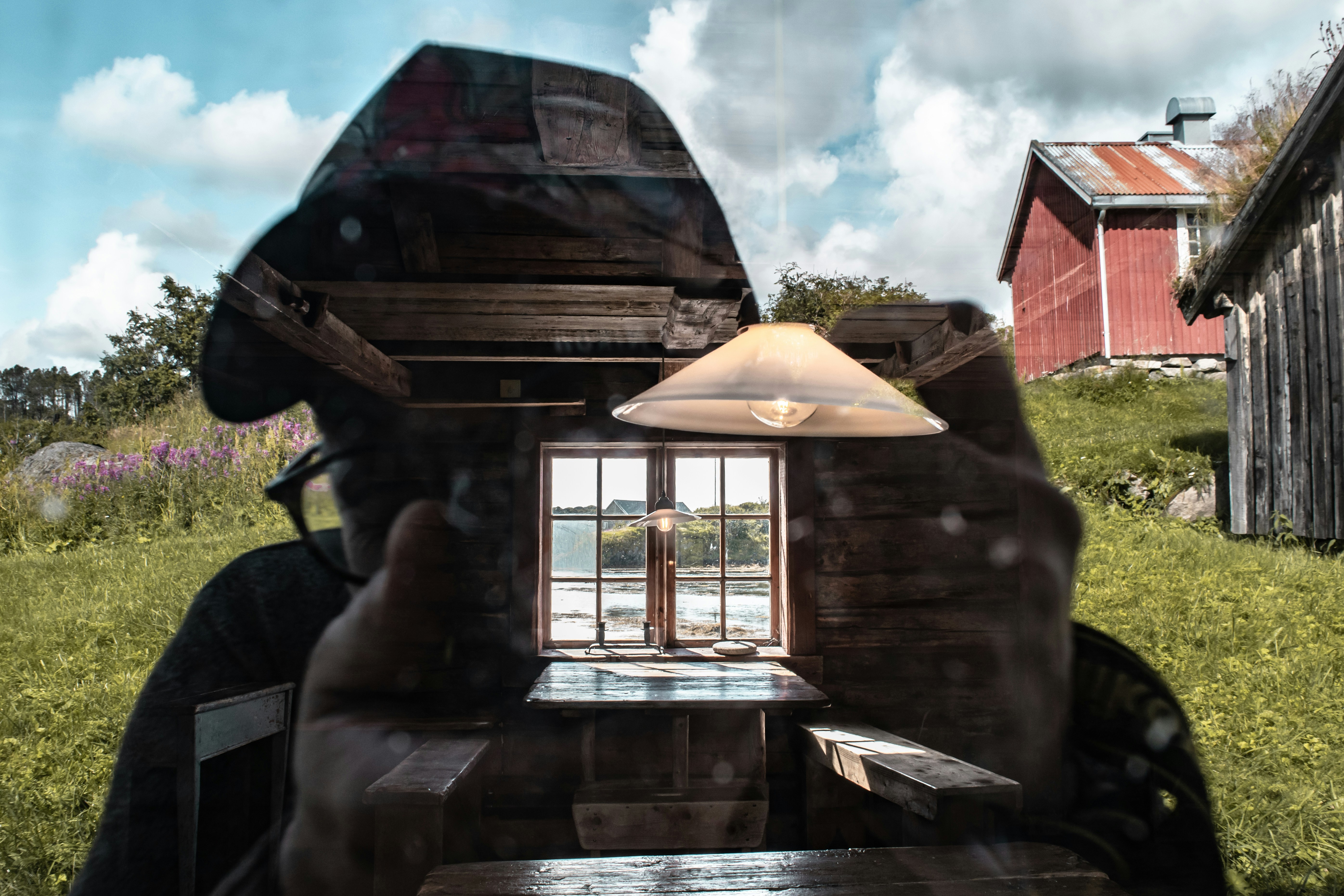 Windowpane Echoes: A Photographer's Reflection in a Rustic Studio