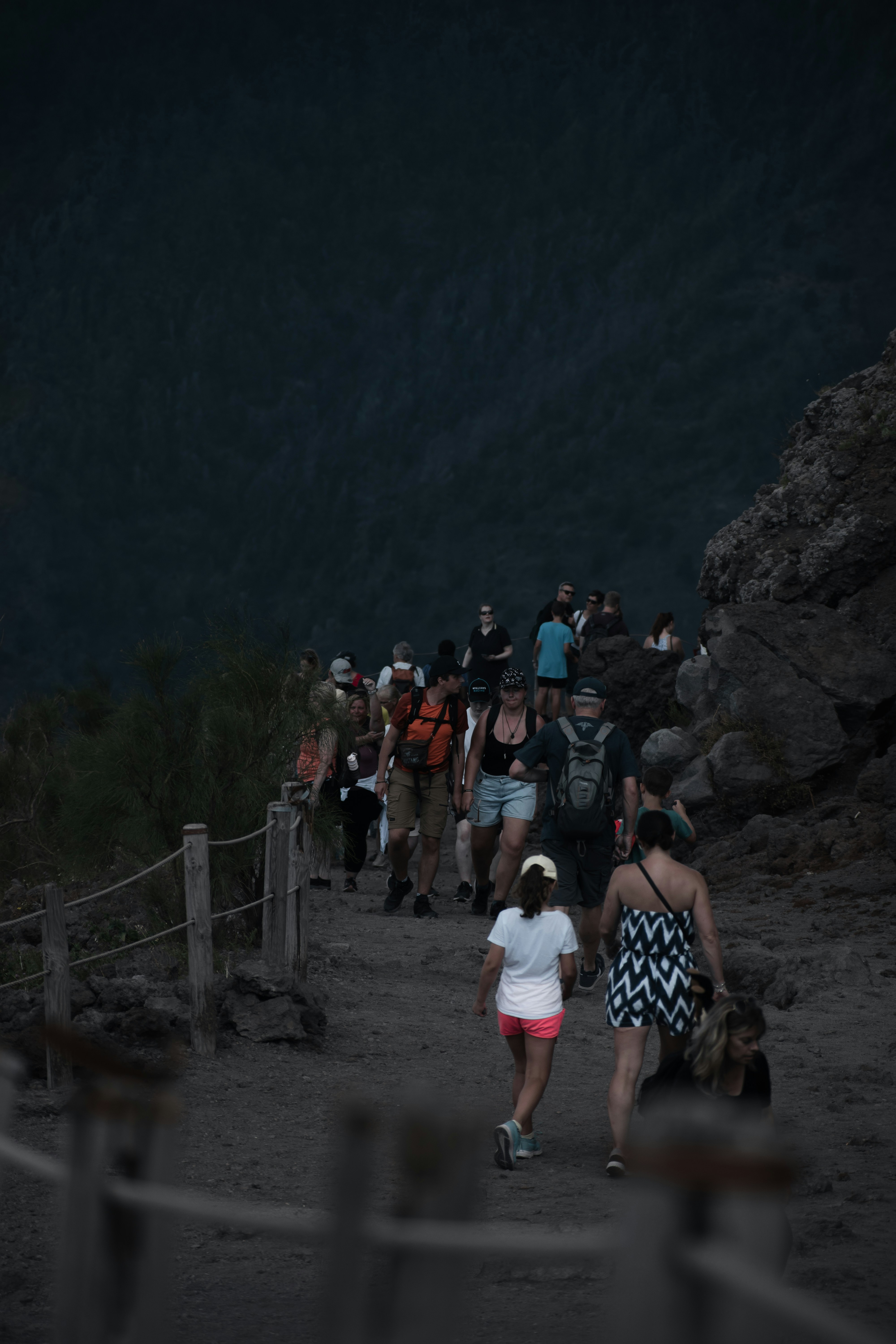 Cliffside Trek at Dusk: A Line of Hikers on a Rugged Path