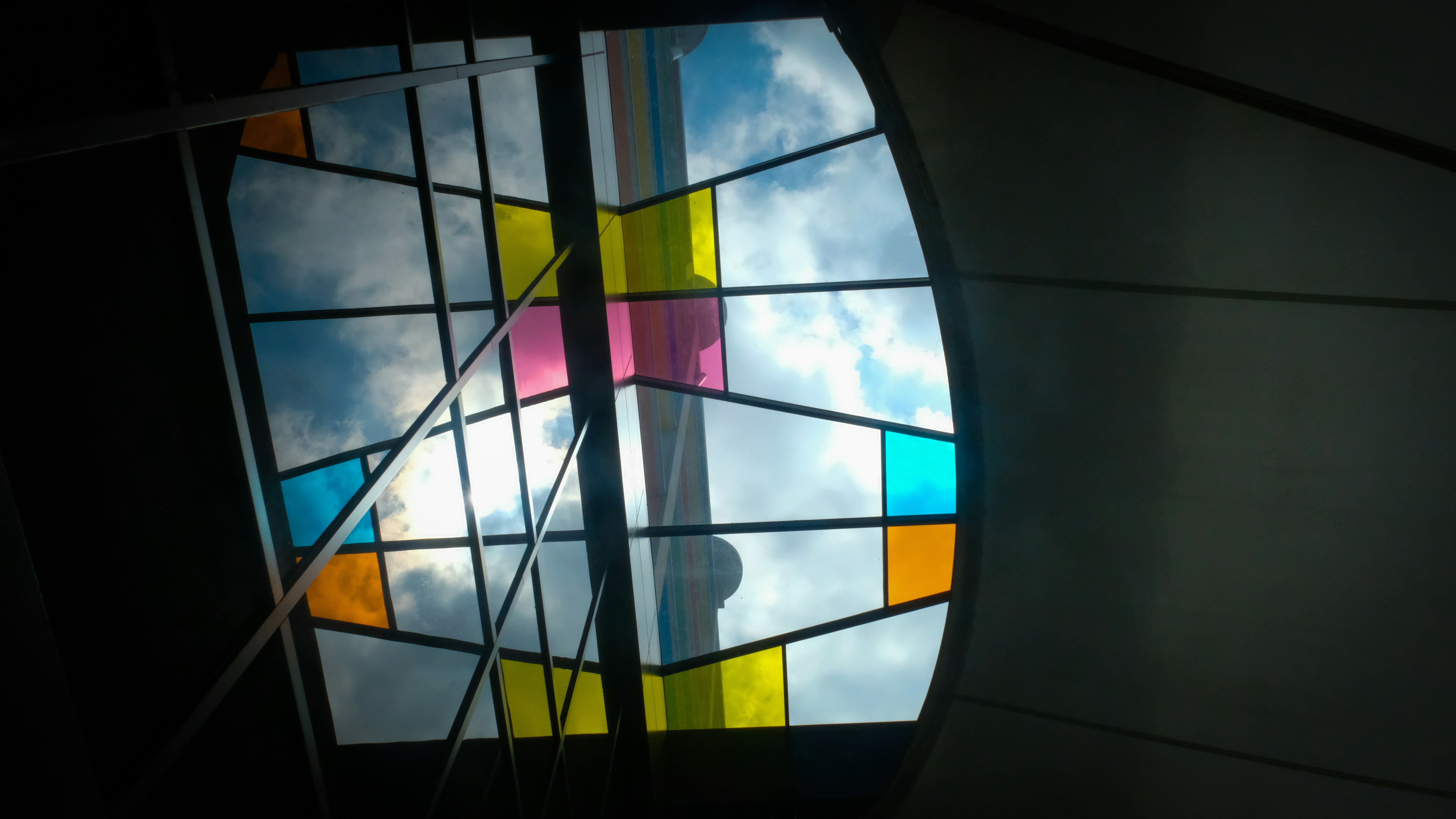 Silhouette in a Prism: A Figure Framed by Colored Glass Under Open Sky