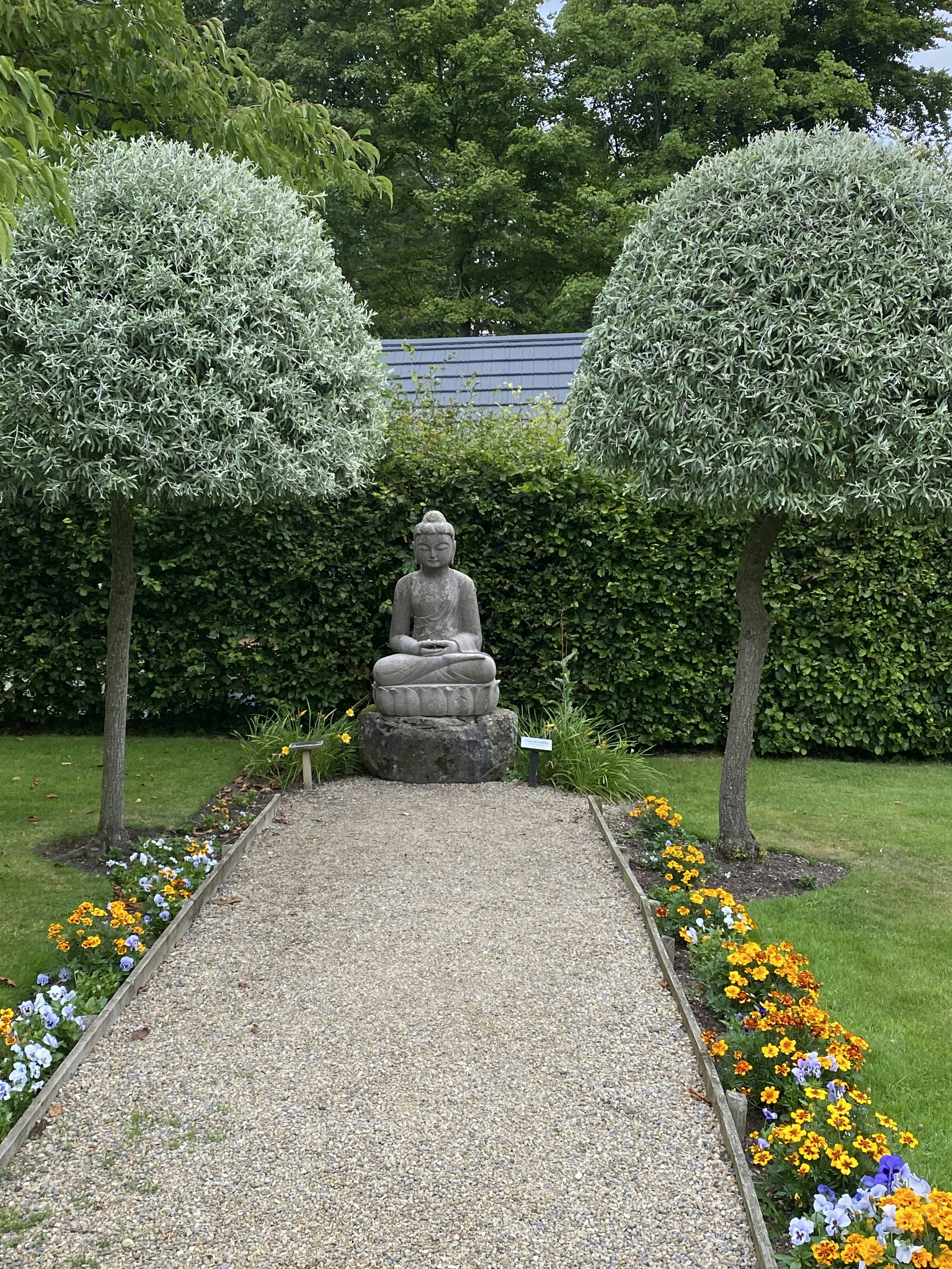 Budda sculpture with trees and path Hymalayan Garden and sculpture Park 