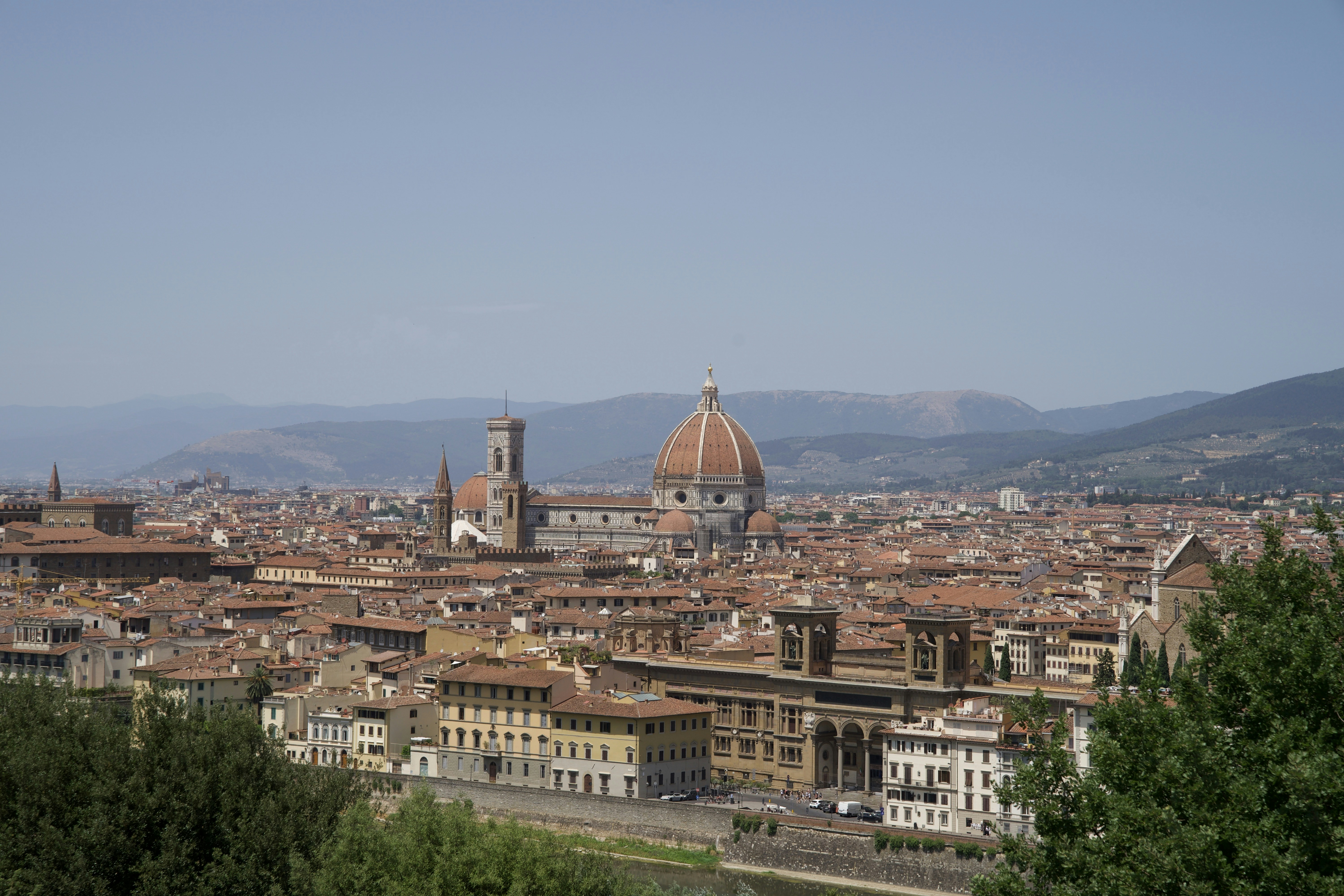 Panoramic view of Florence showcasing the iconic Duomo and historic buildings under a clear blue sky.