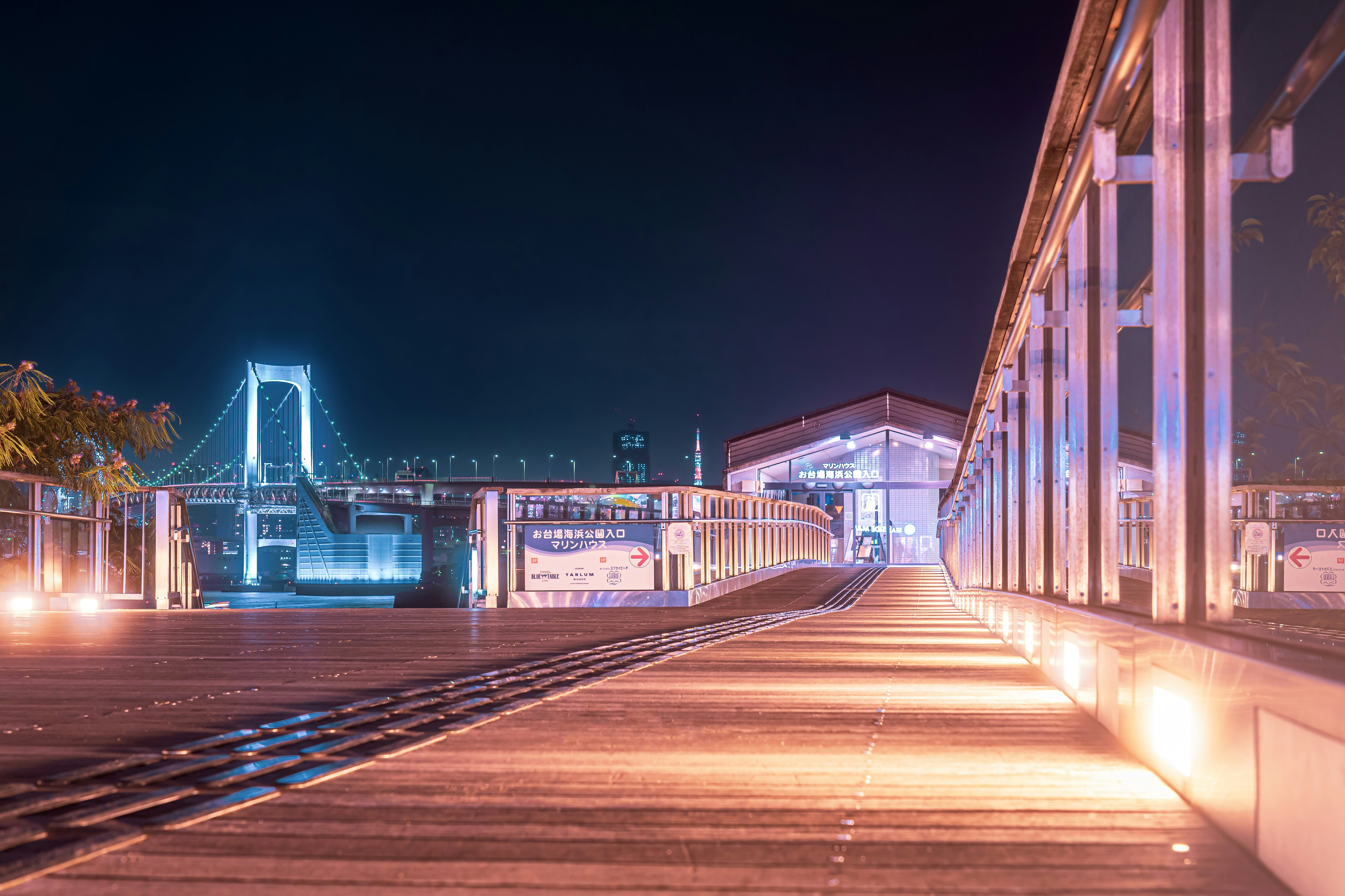 Neon Corridor Toward the Blue-Illuminated Bridge