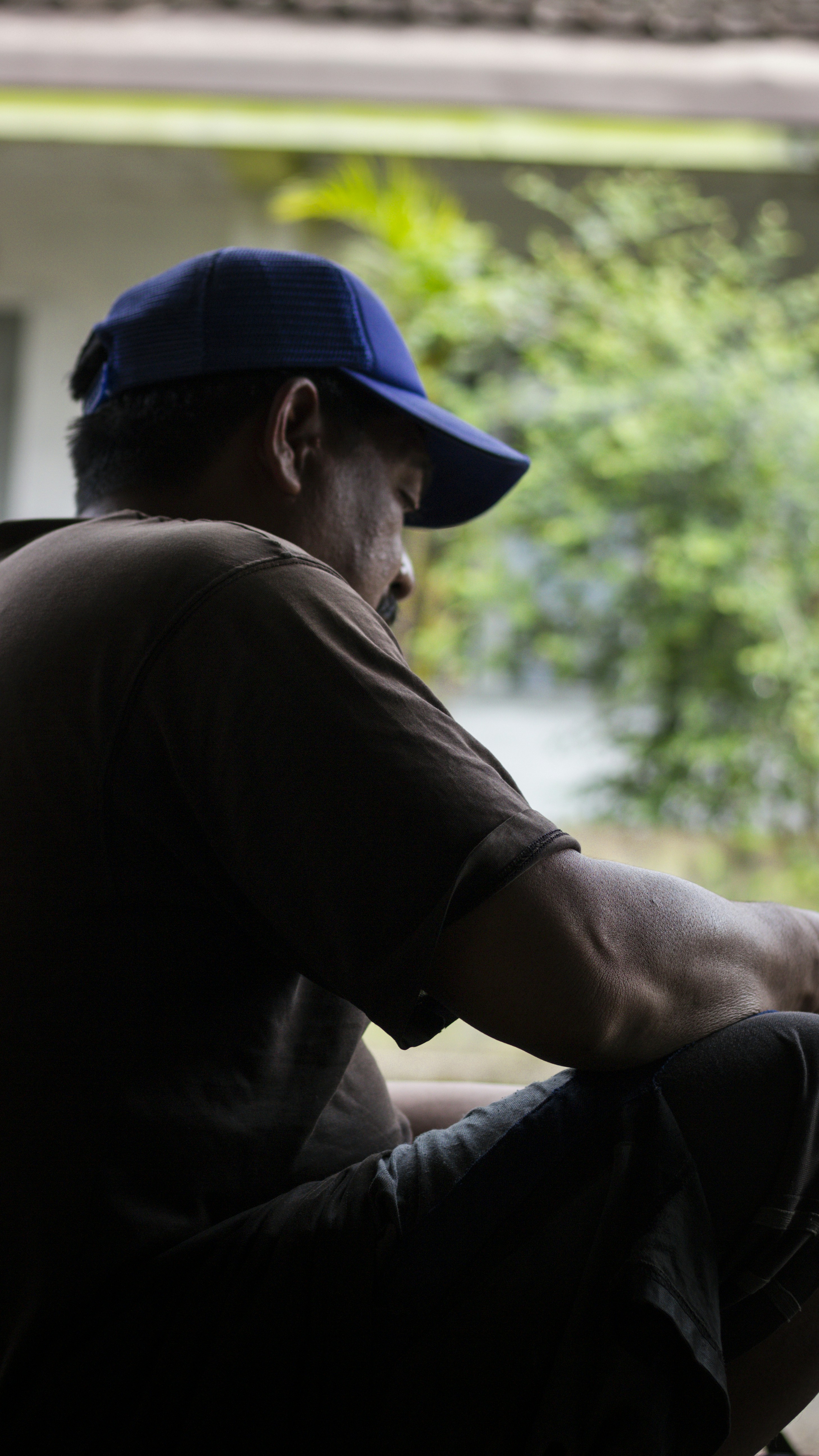 Inward Shade: A Quiet Moment Under a Blue Cap