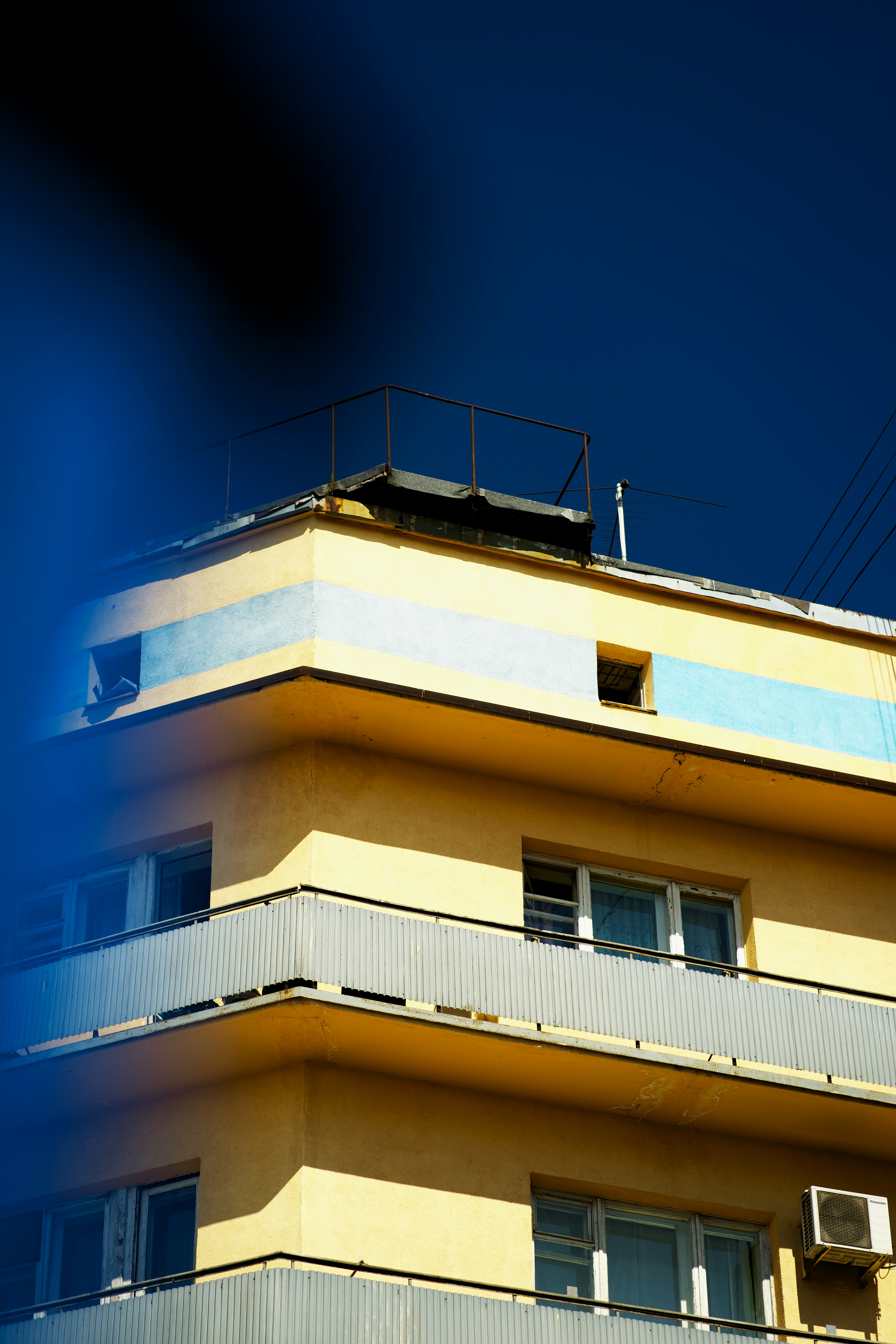 Terraced Yellow and Blue: A Sunlit Block Reaching into a Cobalt Sky