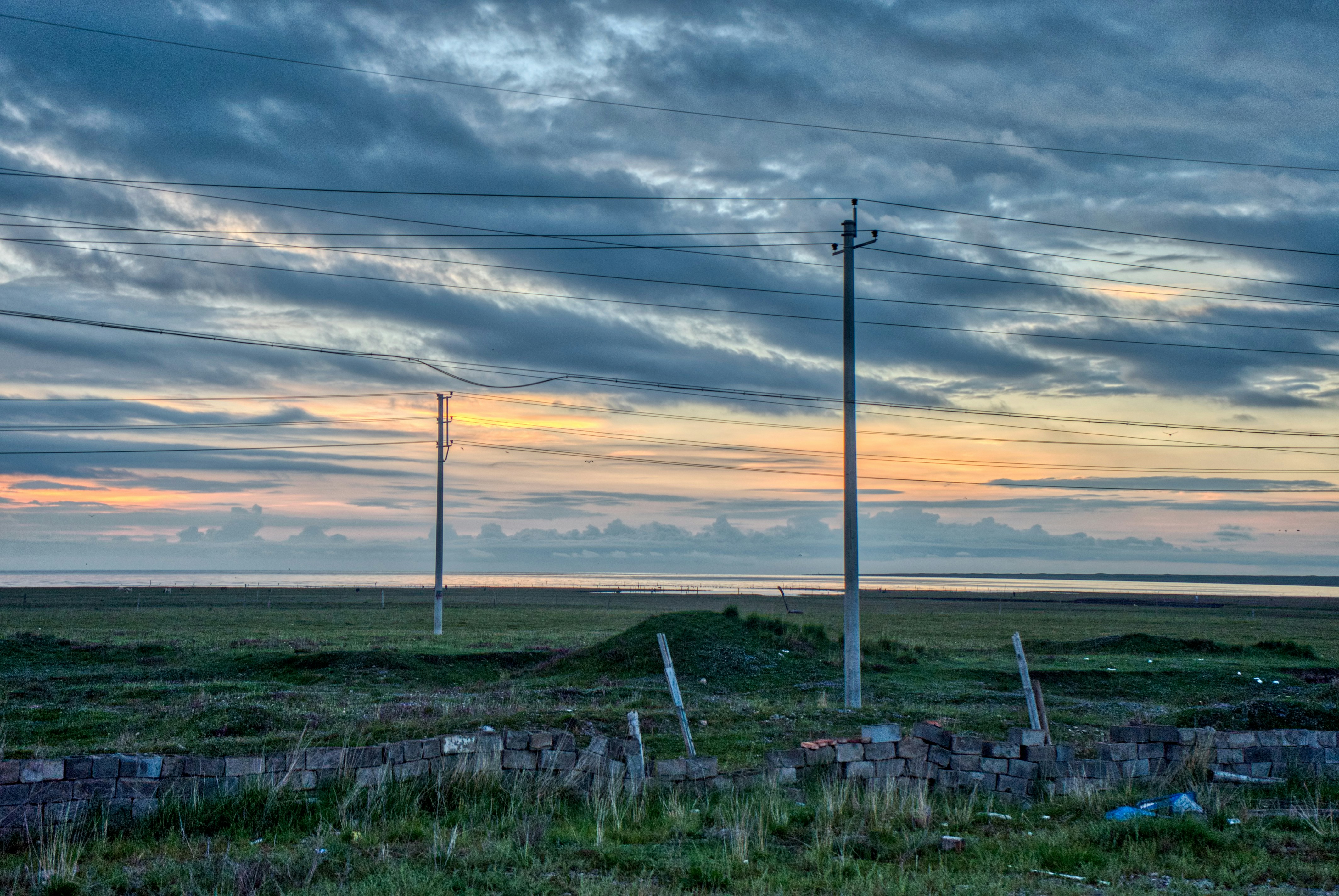 Dusk Over the Flat: Poles Framing a Quiet Horizon