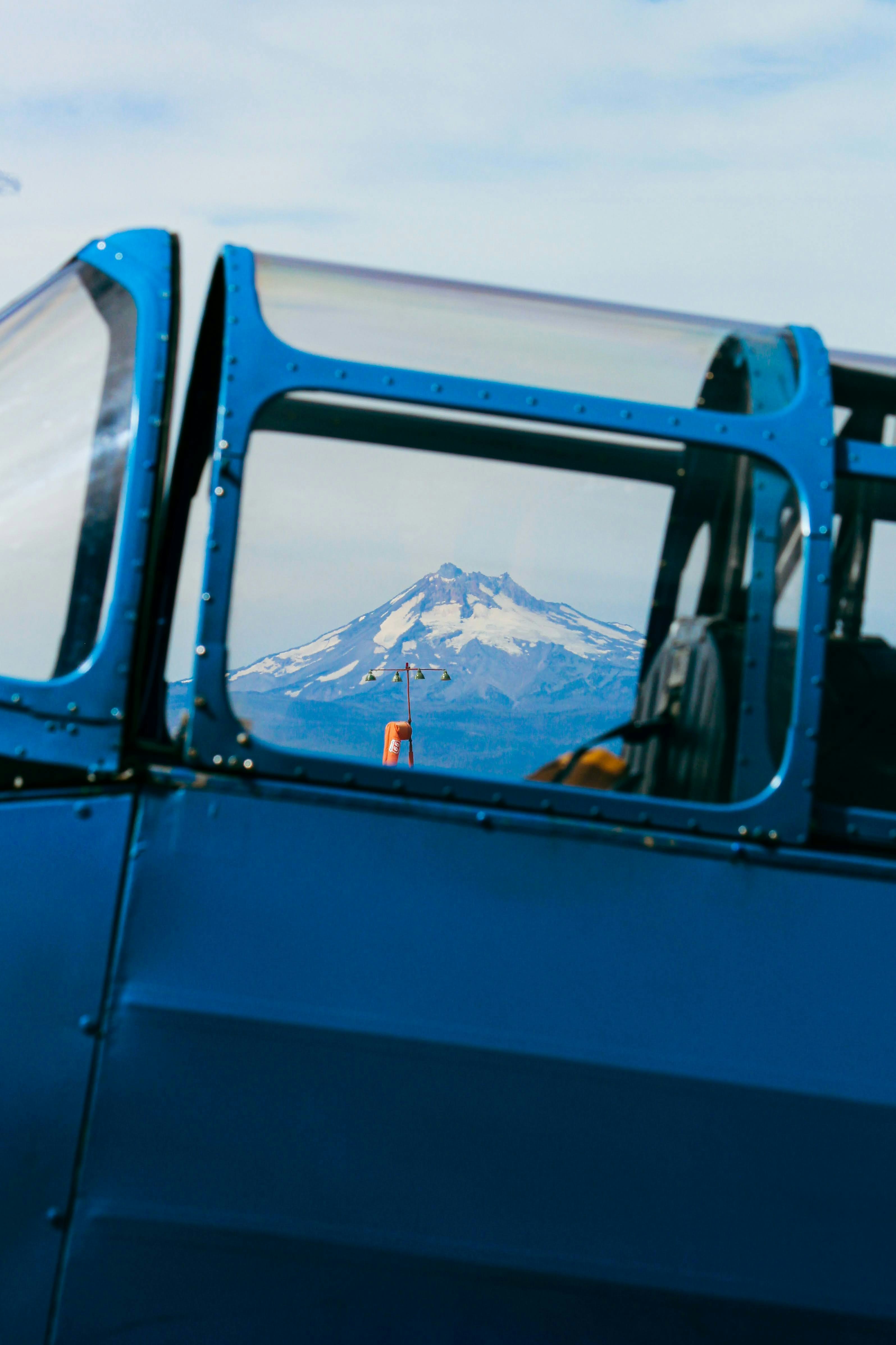 Snow-capped Peak Framed by a Blue Cockpit Window