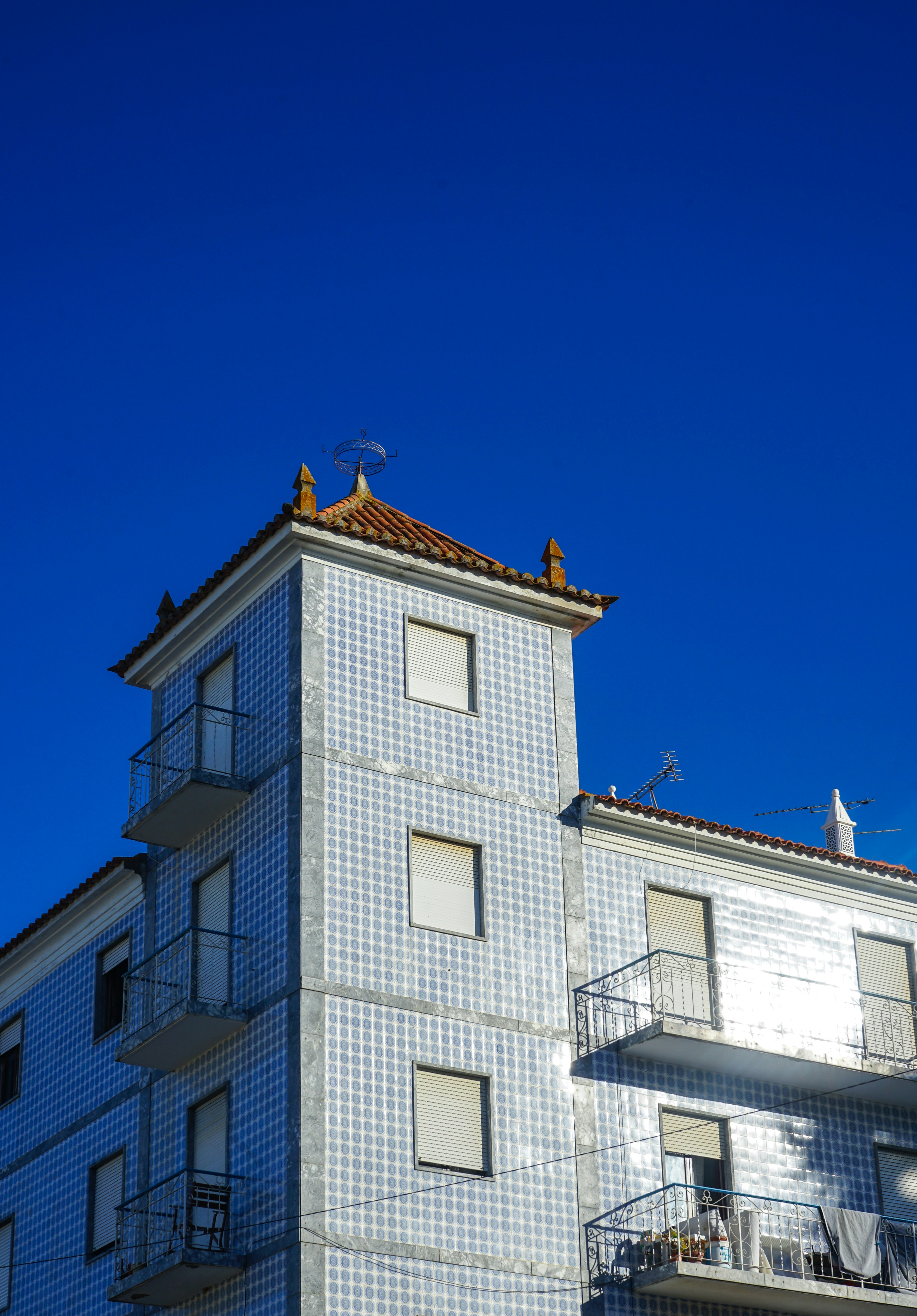 Azure Tilework at a Sunlit Corner Tower with Balcony Outcroppings