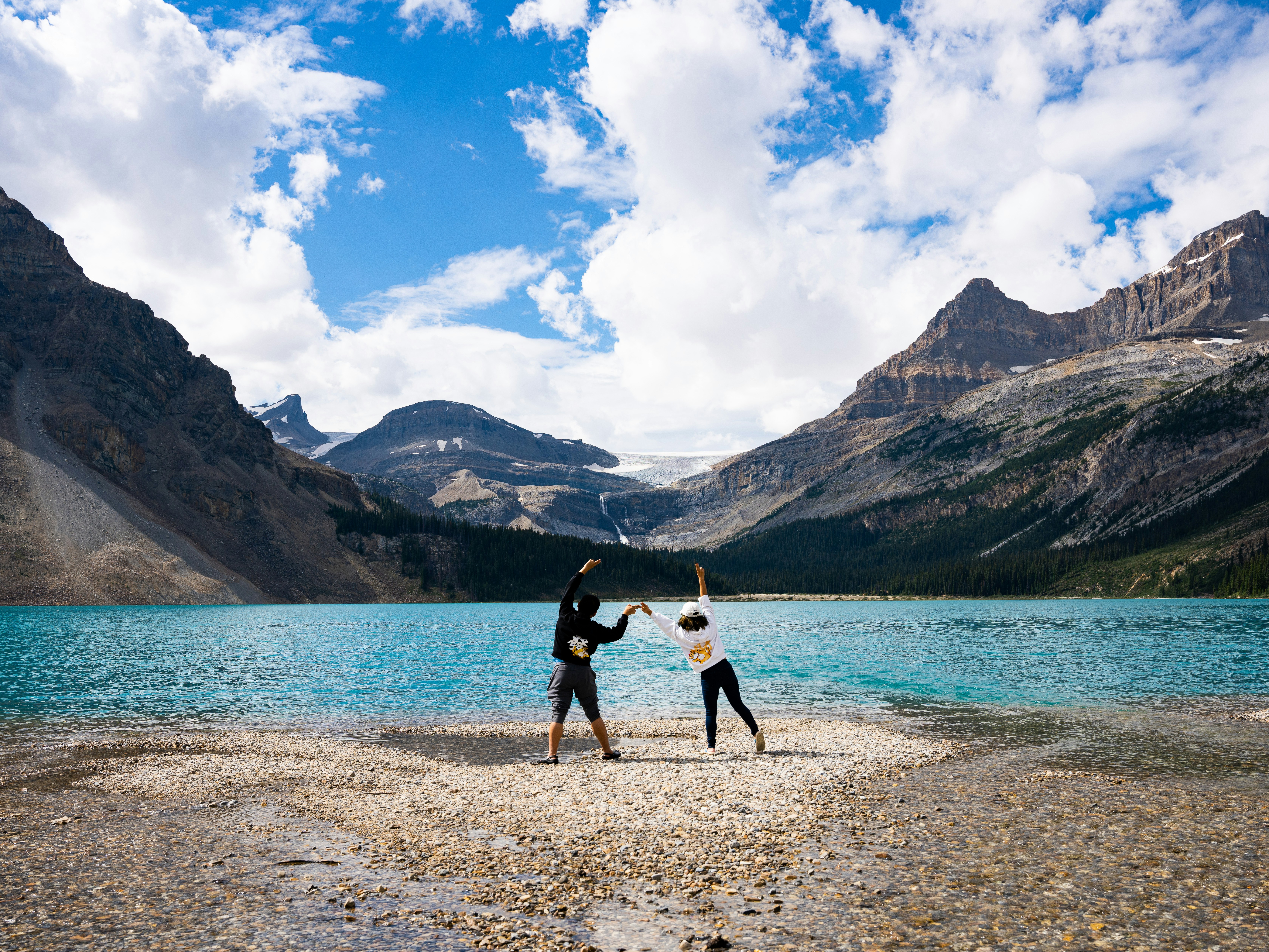 Dancers on a Turquoise Alpine Shore Beneath Jagged Peaks