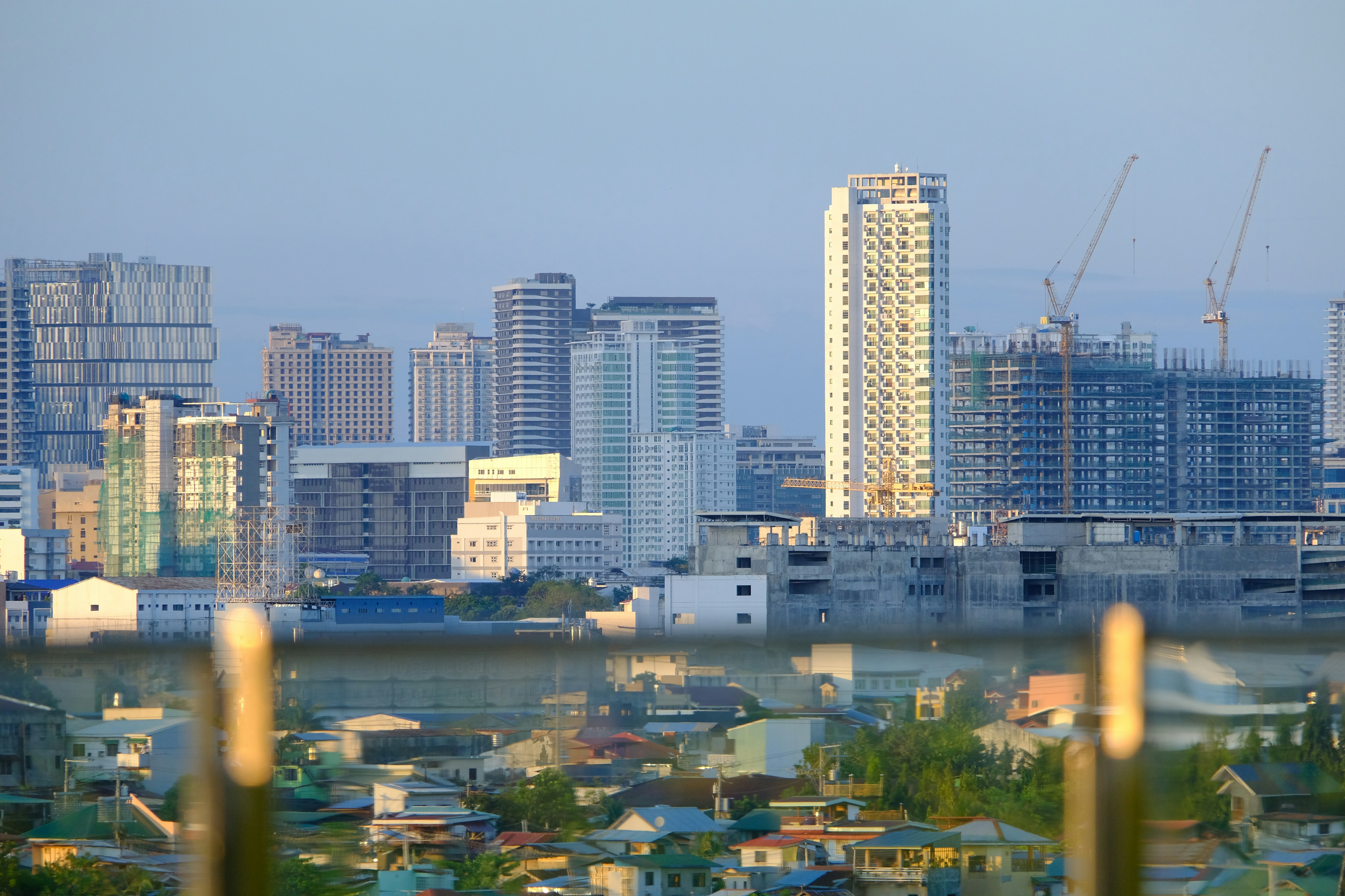 City skyline showcasing a mix of completed and under-construction buildings against a clear sky.