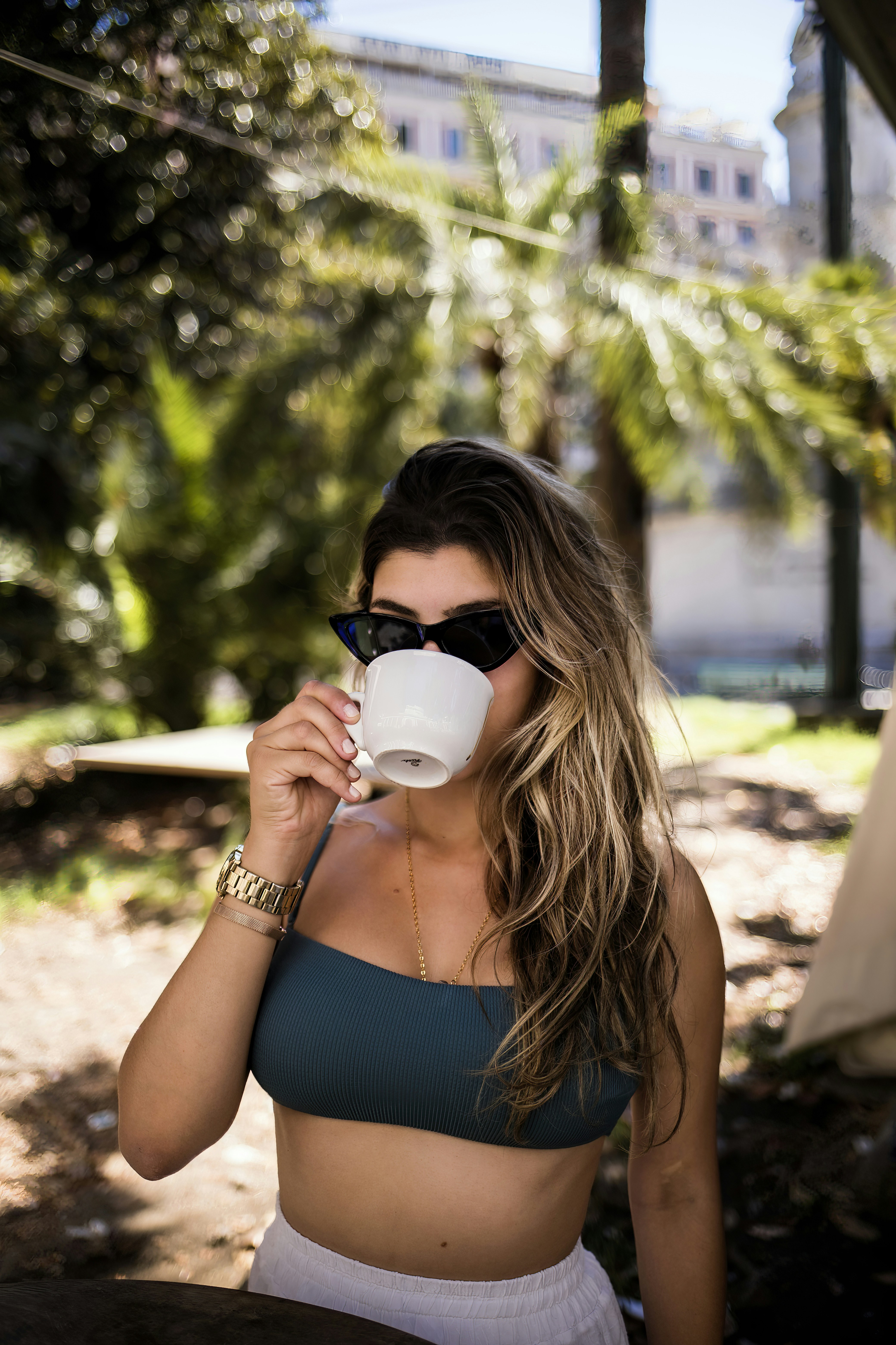 Cafe Confidence: A Sunlit Moment Behind Sunglasses and Sip