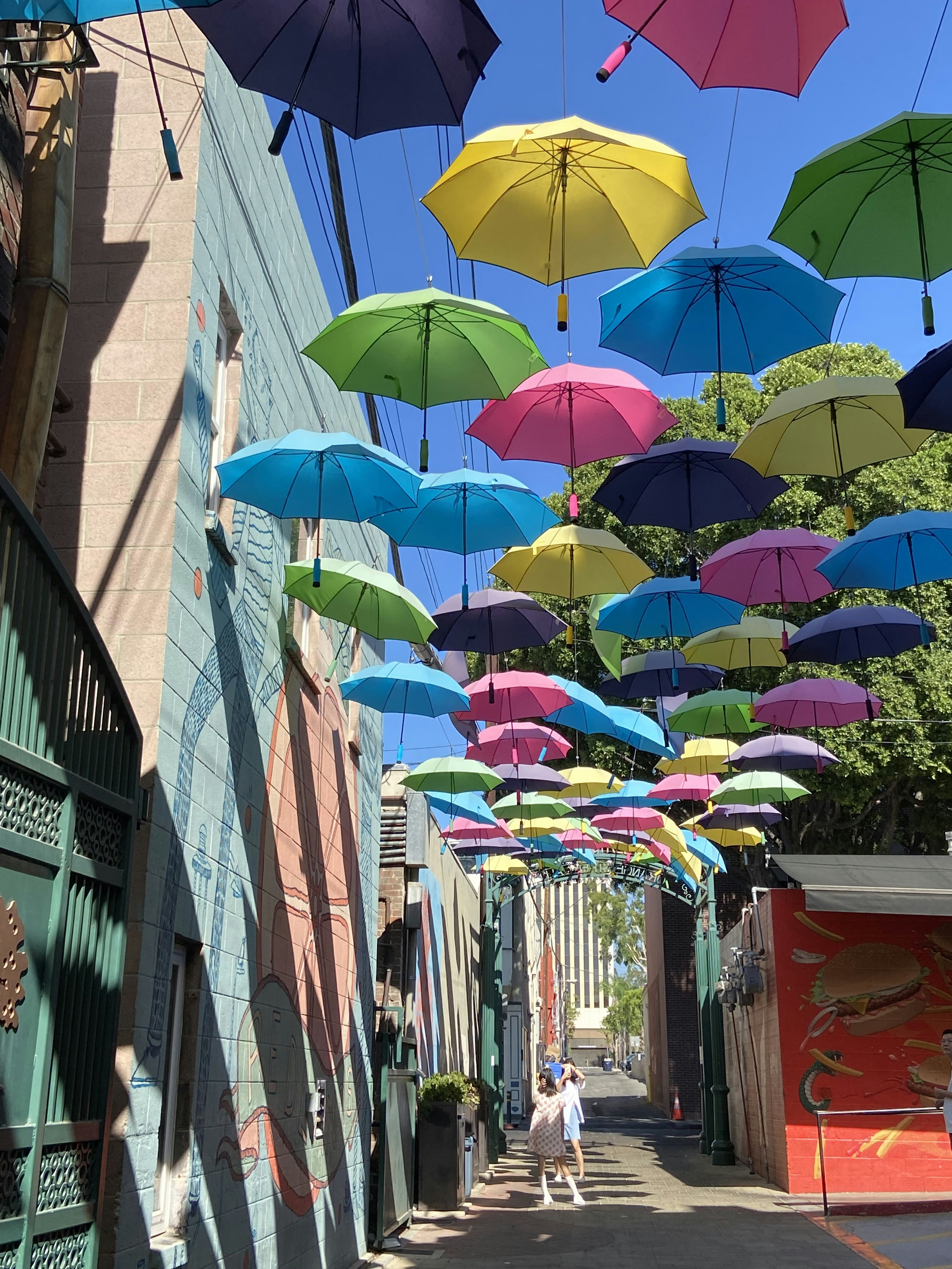 A group of colorful umbrellas swing from a building photo – Free ...