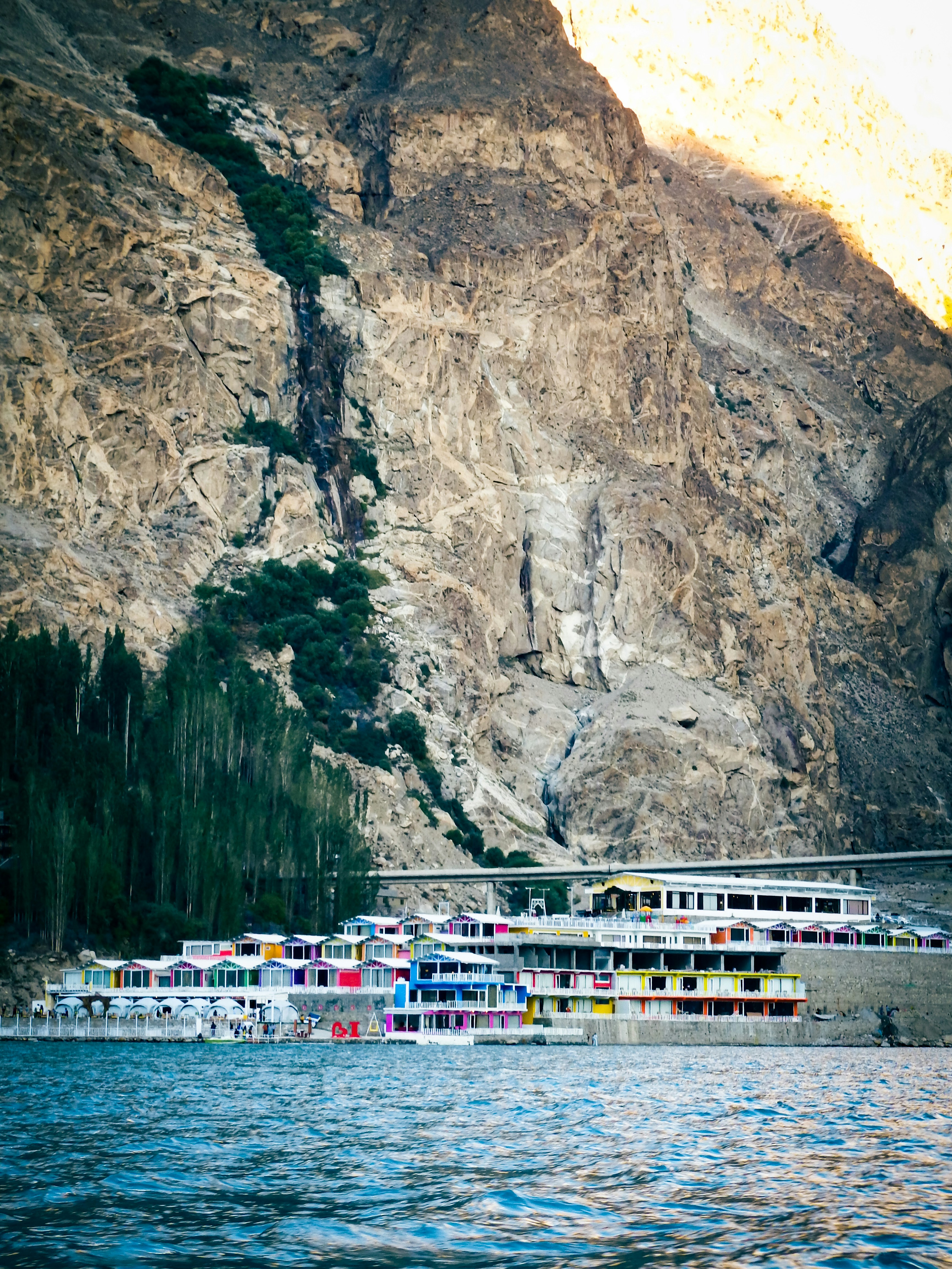 Colorful Houseboats at the Base of a Rocky Cliff