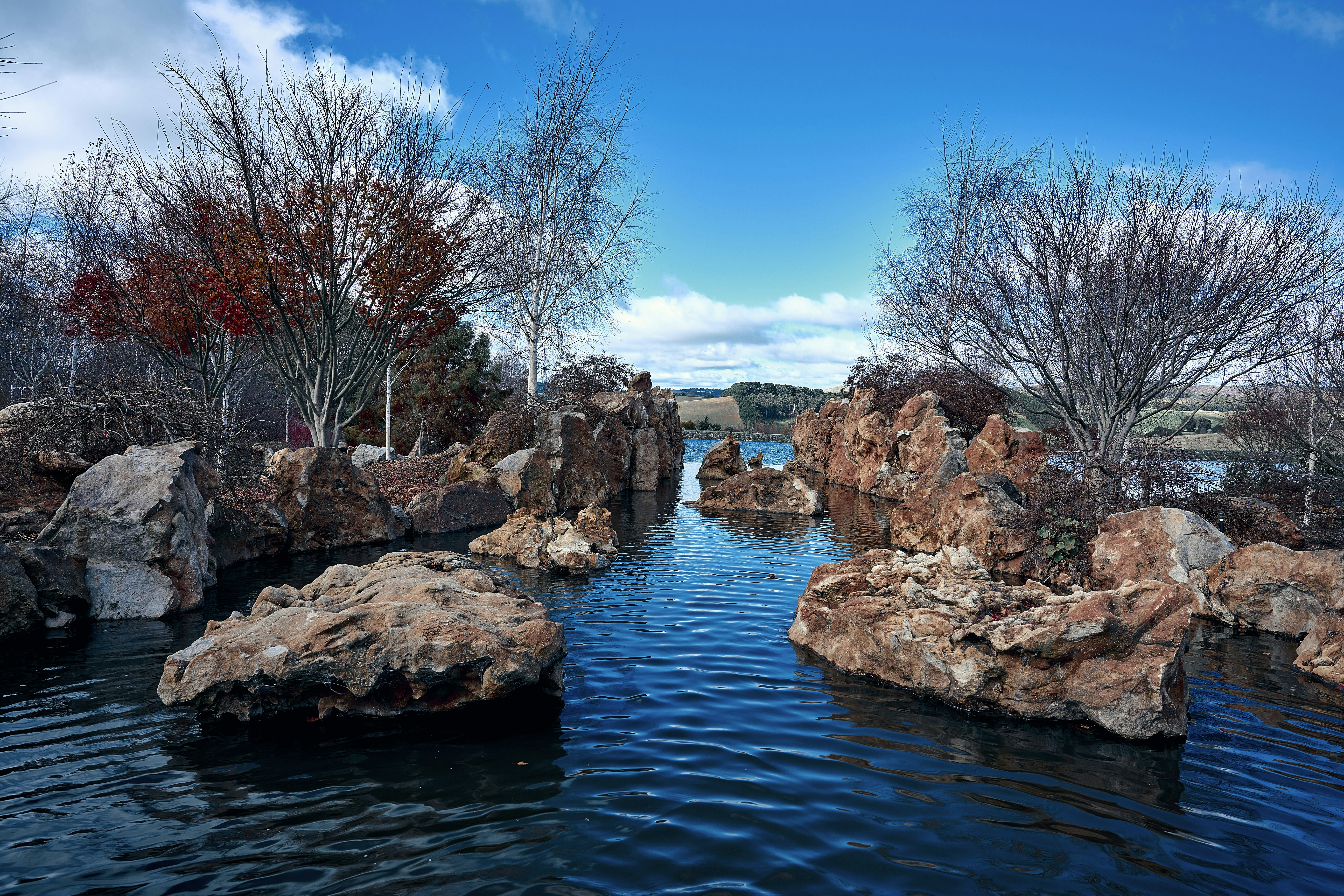 A body of water with rocks and trees around it photo – Free Oberon nsw ...