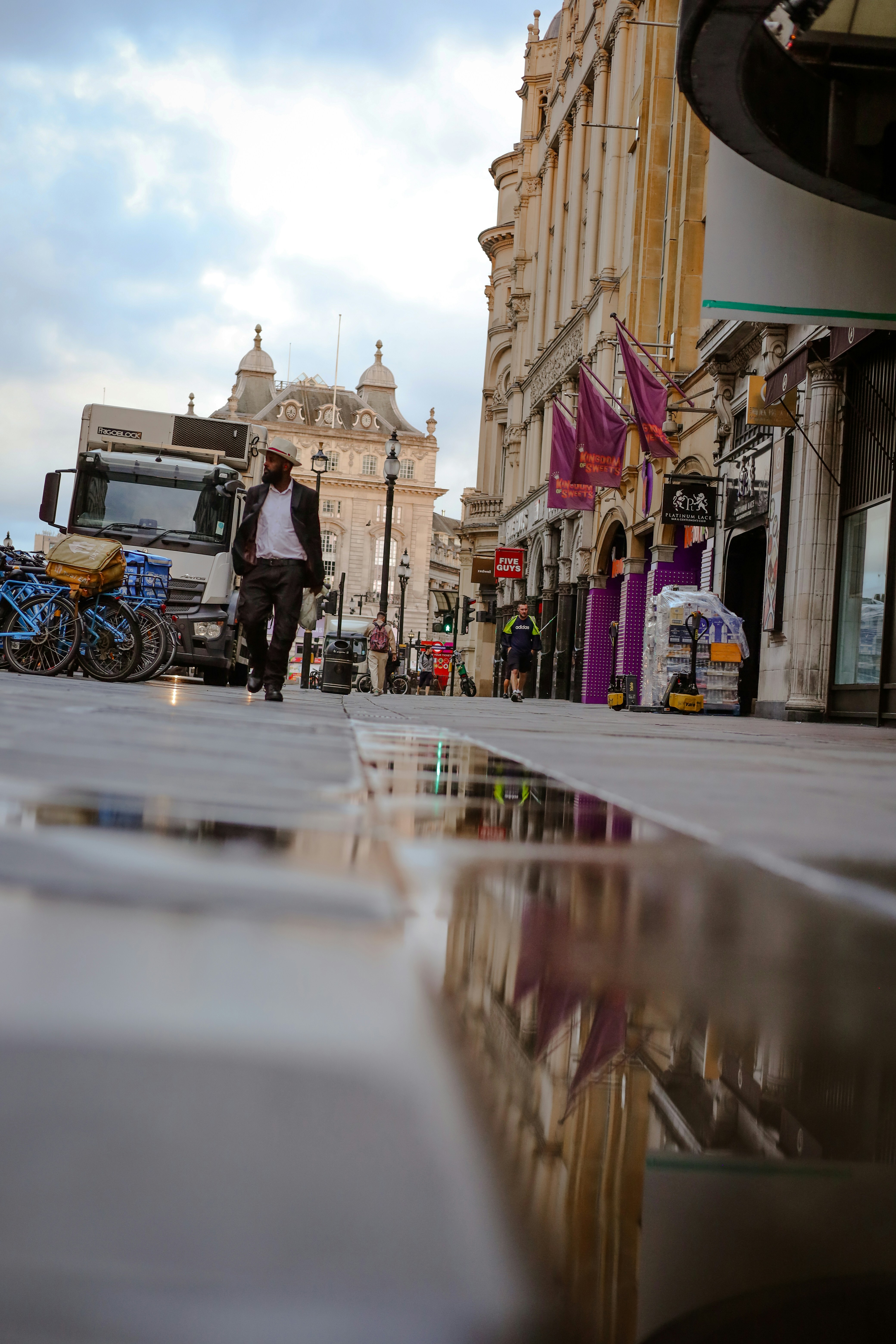 Pavement Portrait in a Rain-Washed City: A Suit-Clad Walker Amid Historic Facades