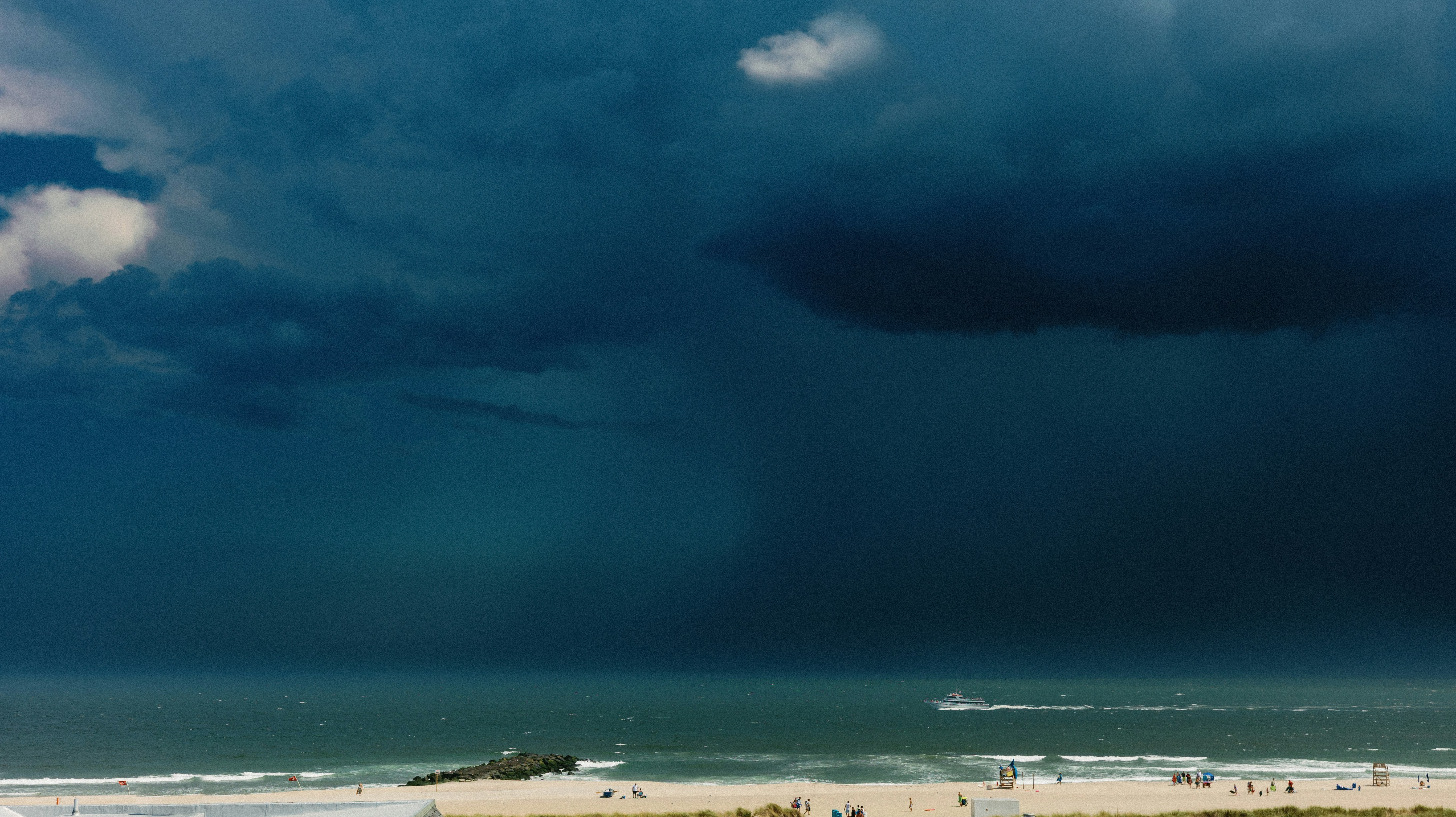 a beach with a body of water and clouds in the sky