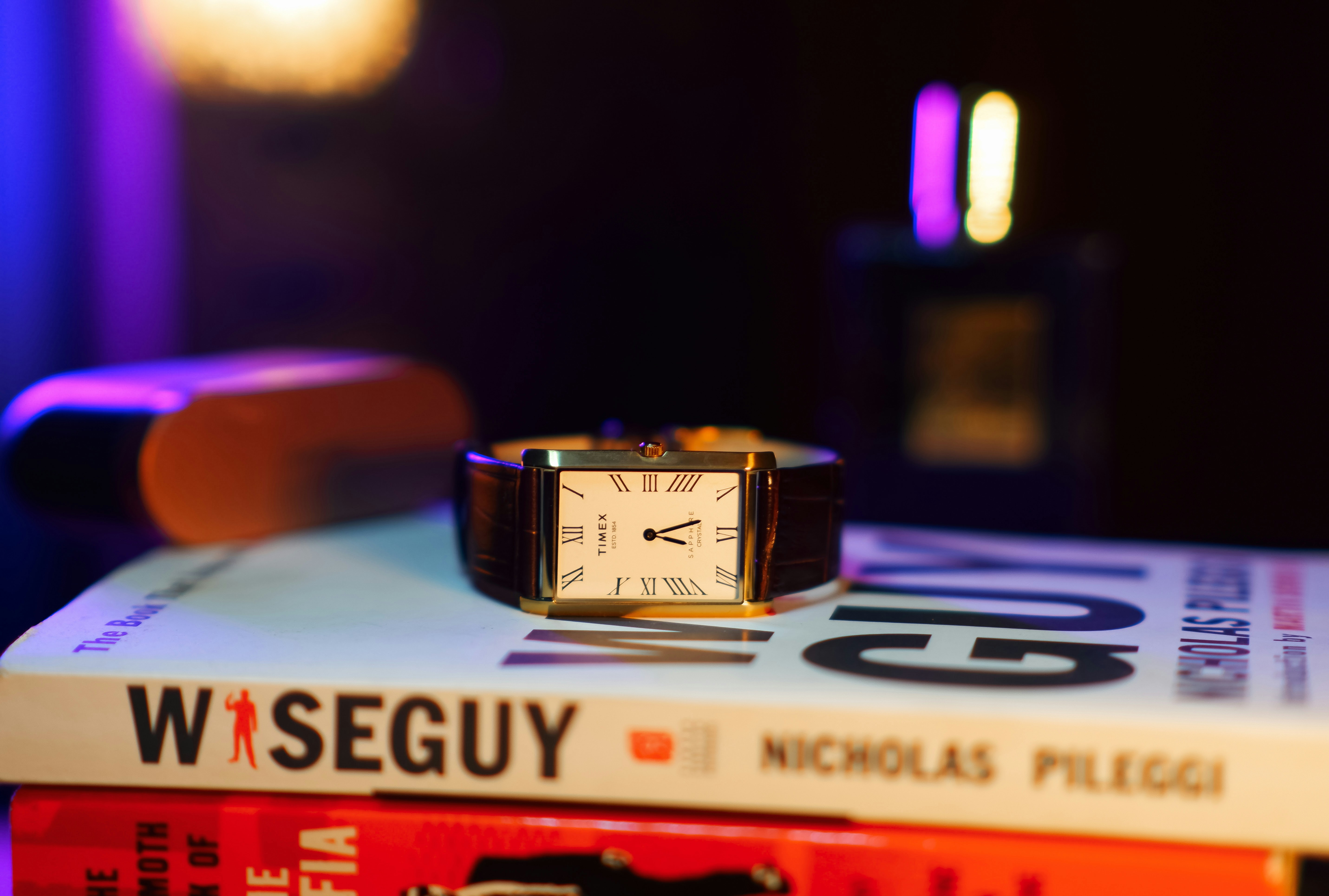 Time on the Shelf: A Leather-Banded Watch Resting atop a Stack of Books