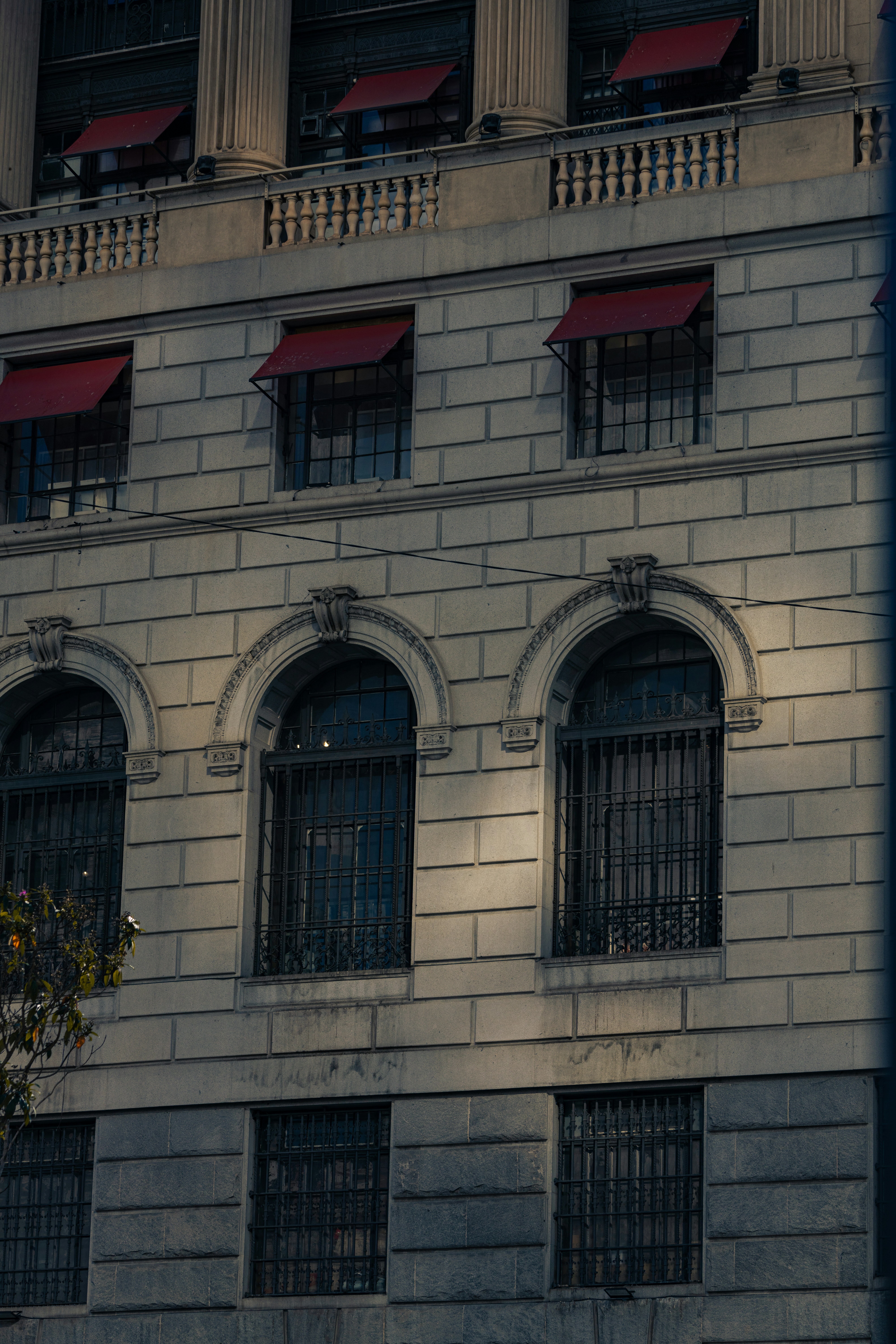 Stone Archive: Arched Windows and Red Awnings on a Classical Facade