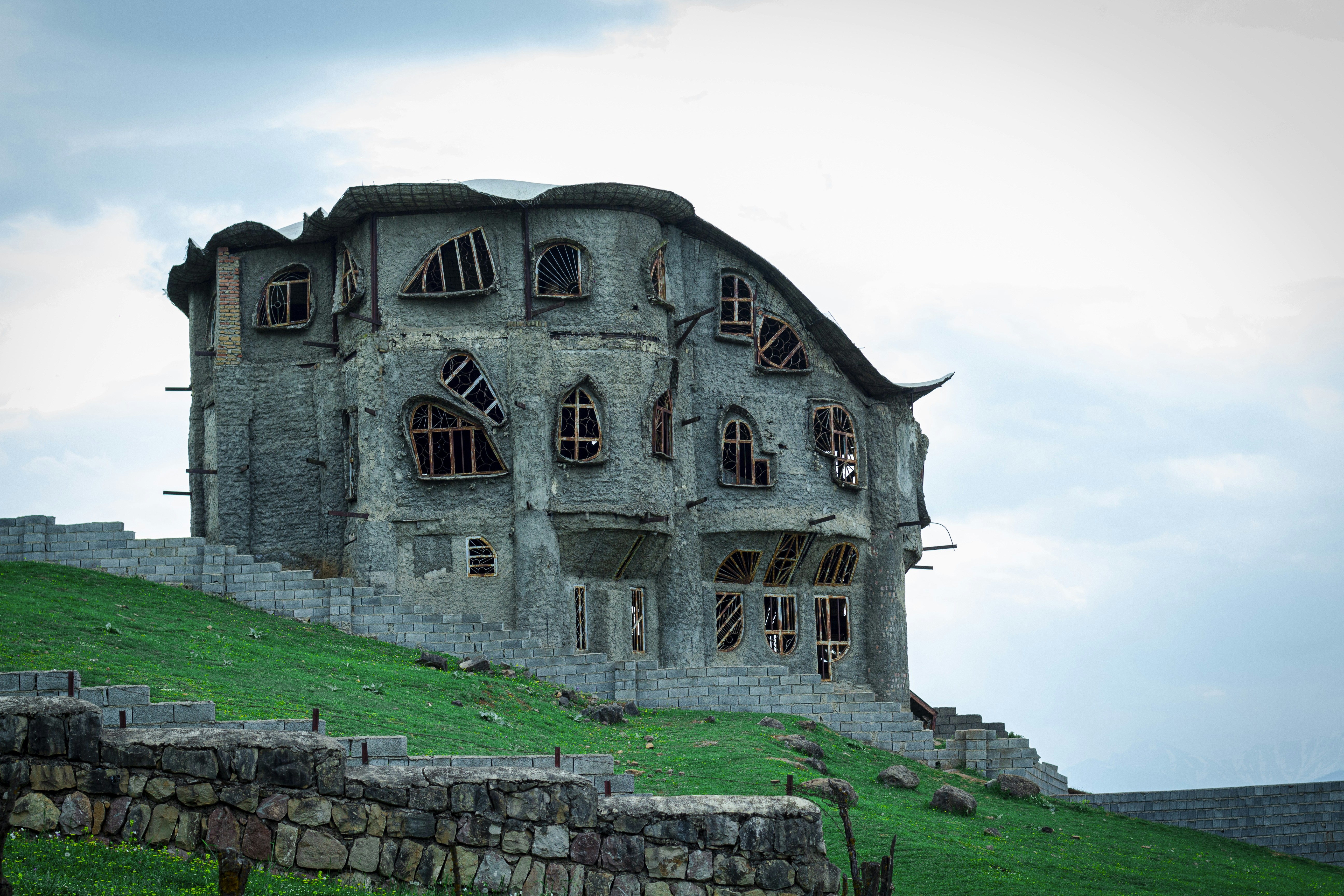 Curved Fortress on the Hill: A Weathered Brick House with Arched Windows