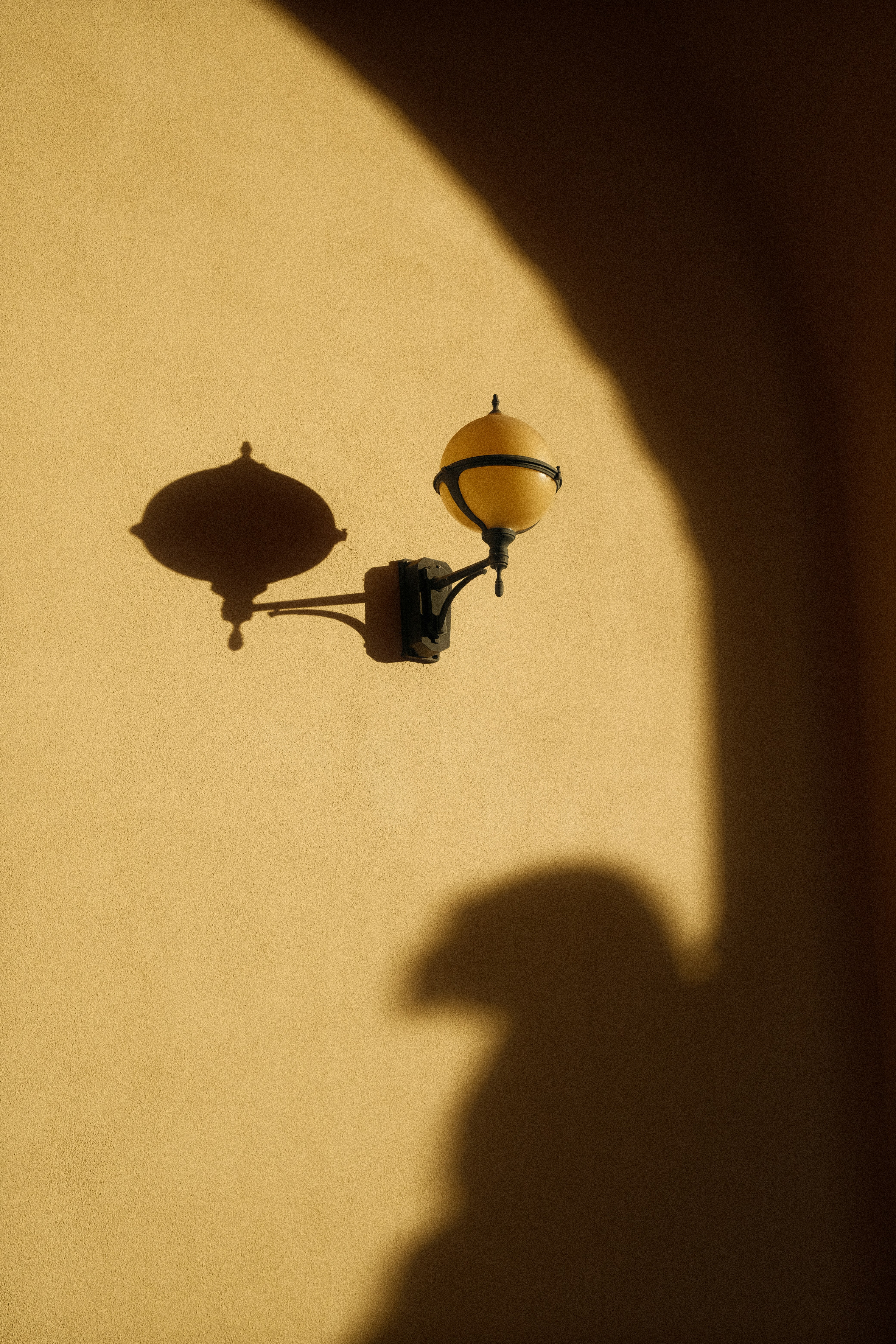 Lantern and Its Shadow: Geometry of Light on an Ochre Wall