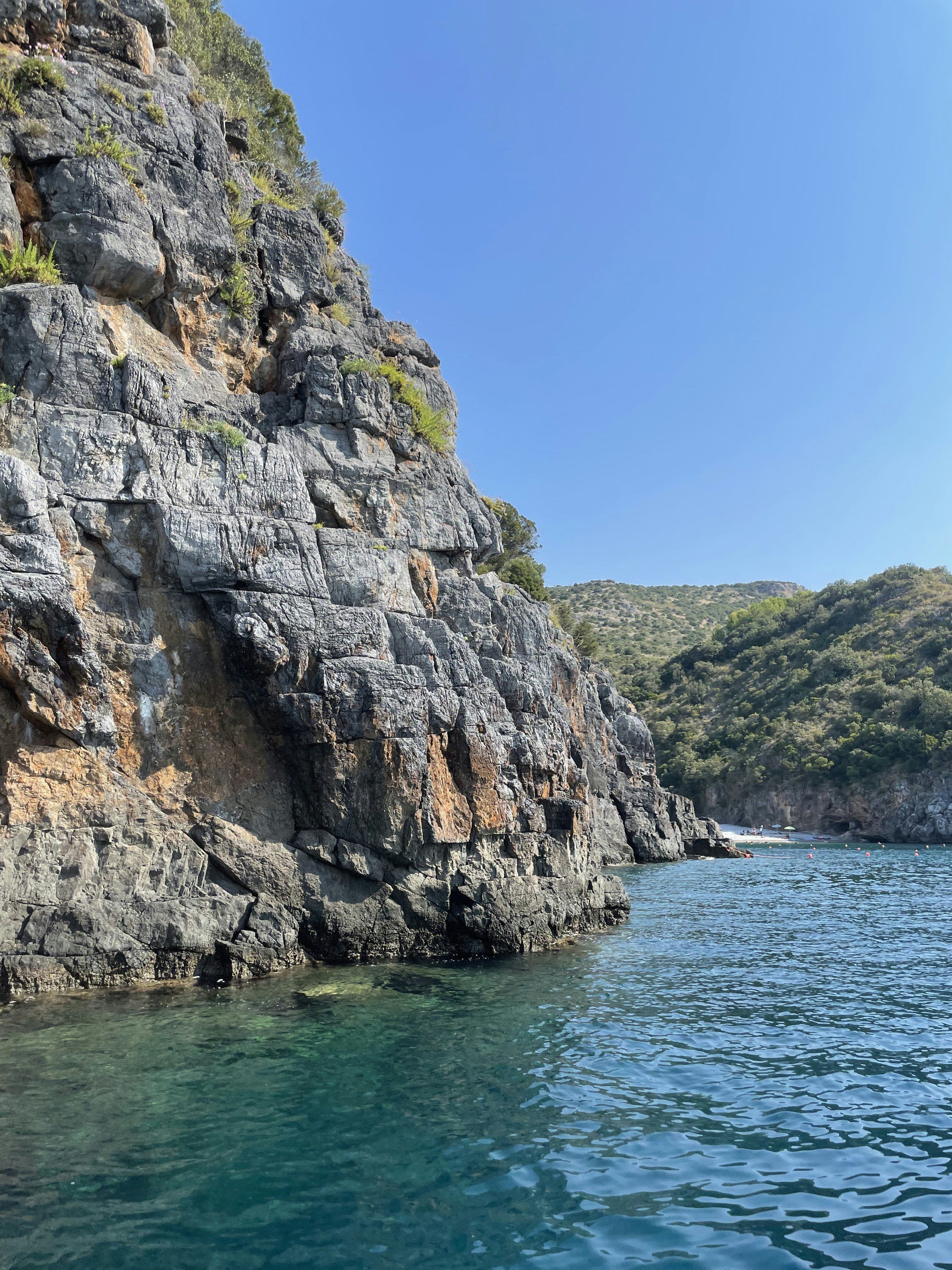 A cliff side with a body of water below photo – Free Italy Image on ...