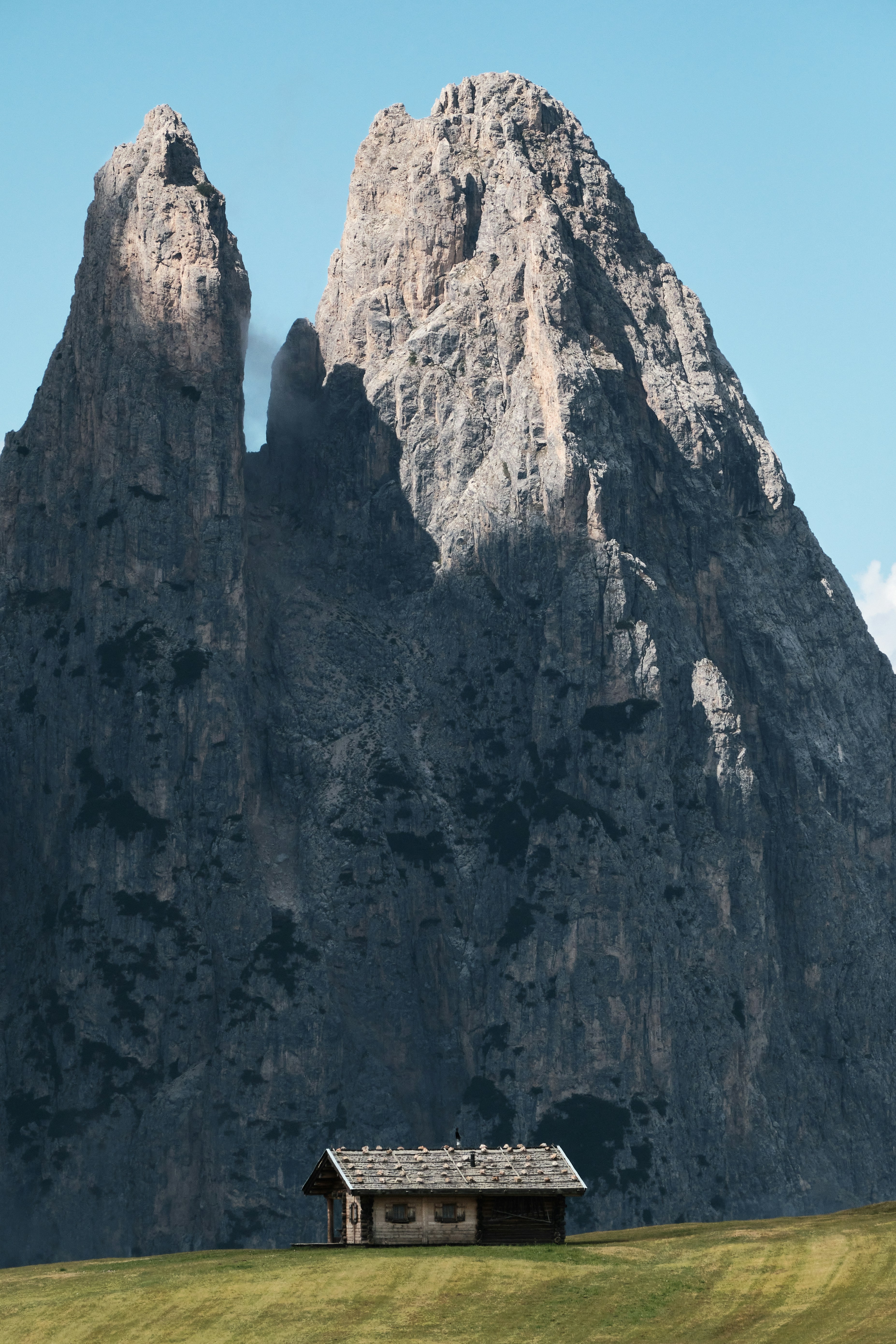 a small house in front of a large rock formation