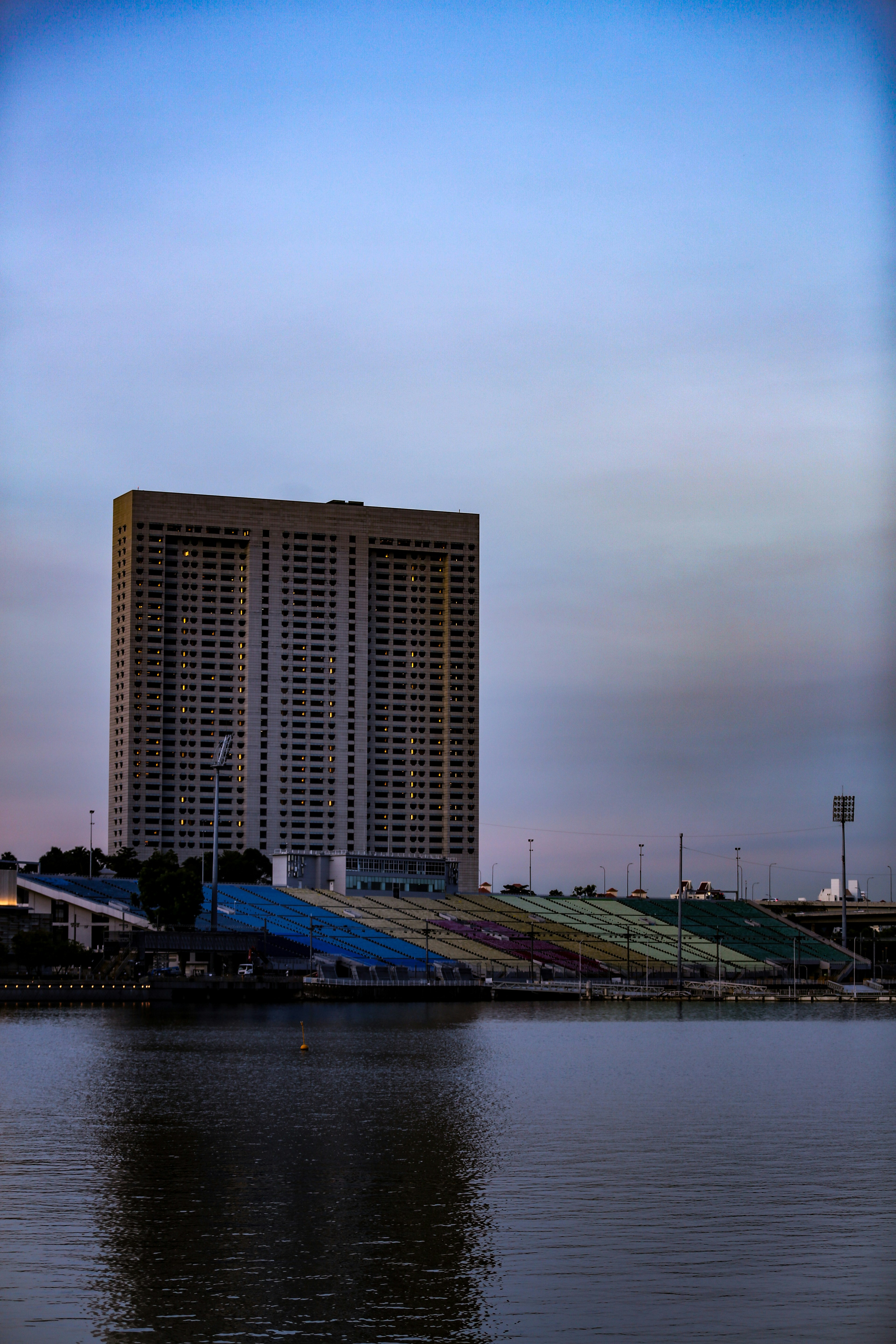 Dusk at Riverfront: A Grid-Pattern Tower Reigns Over Quiet Waters