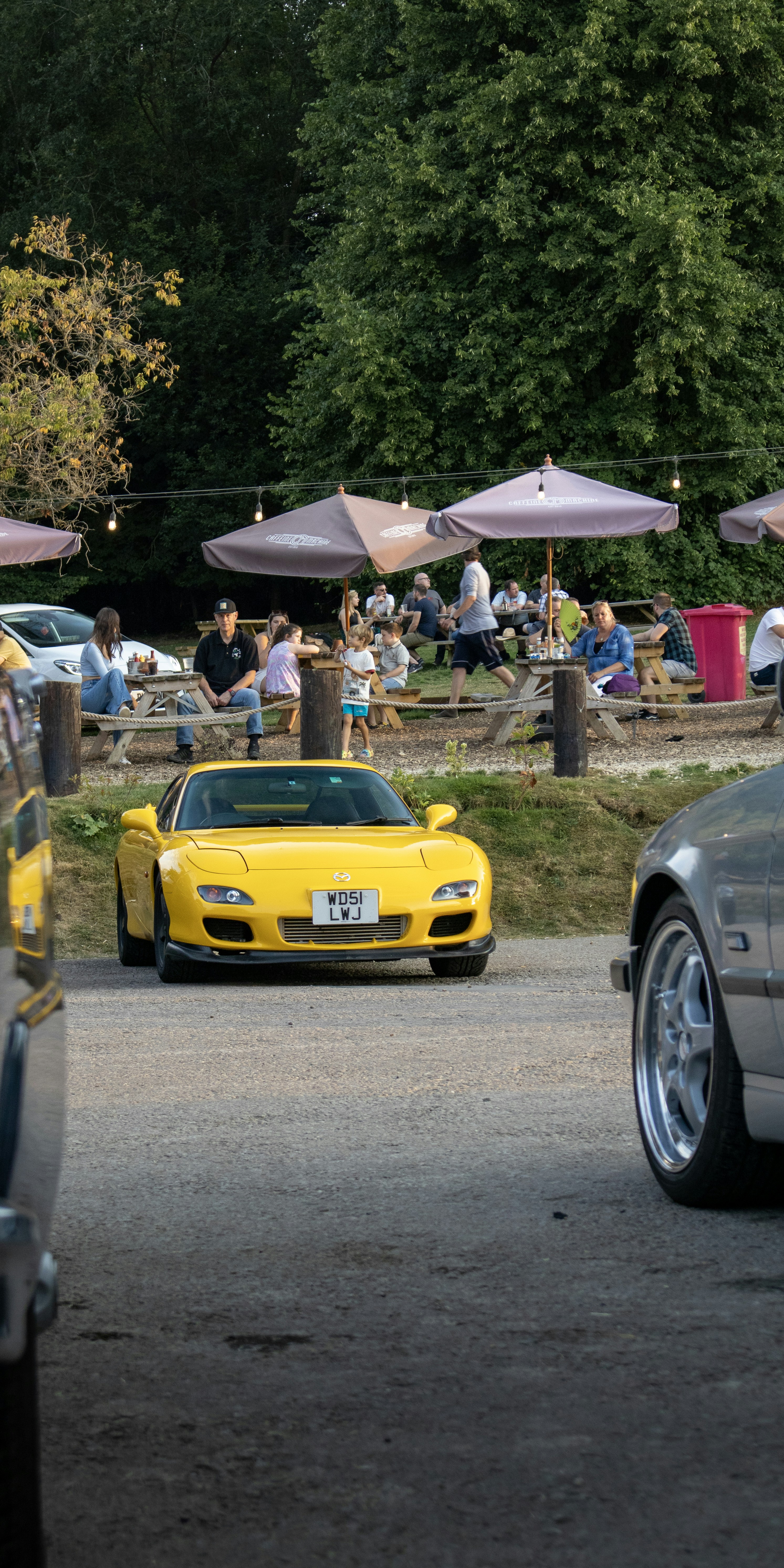 A yellow sports car parked in front of a crowd of people photo – Free ...