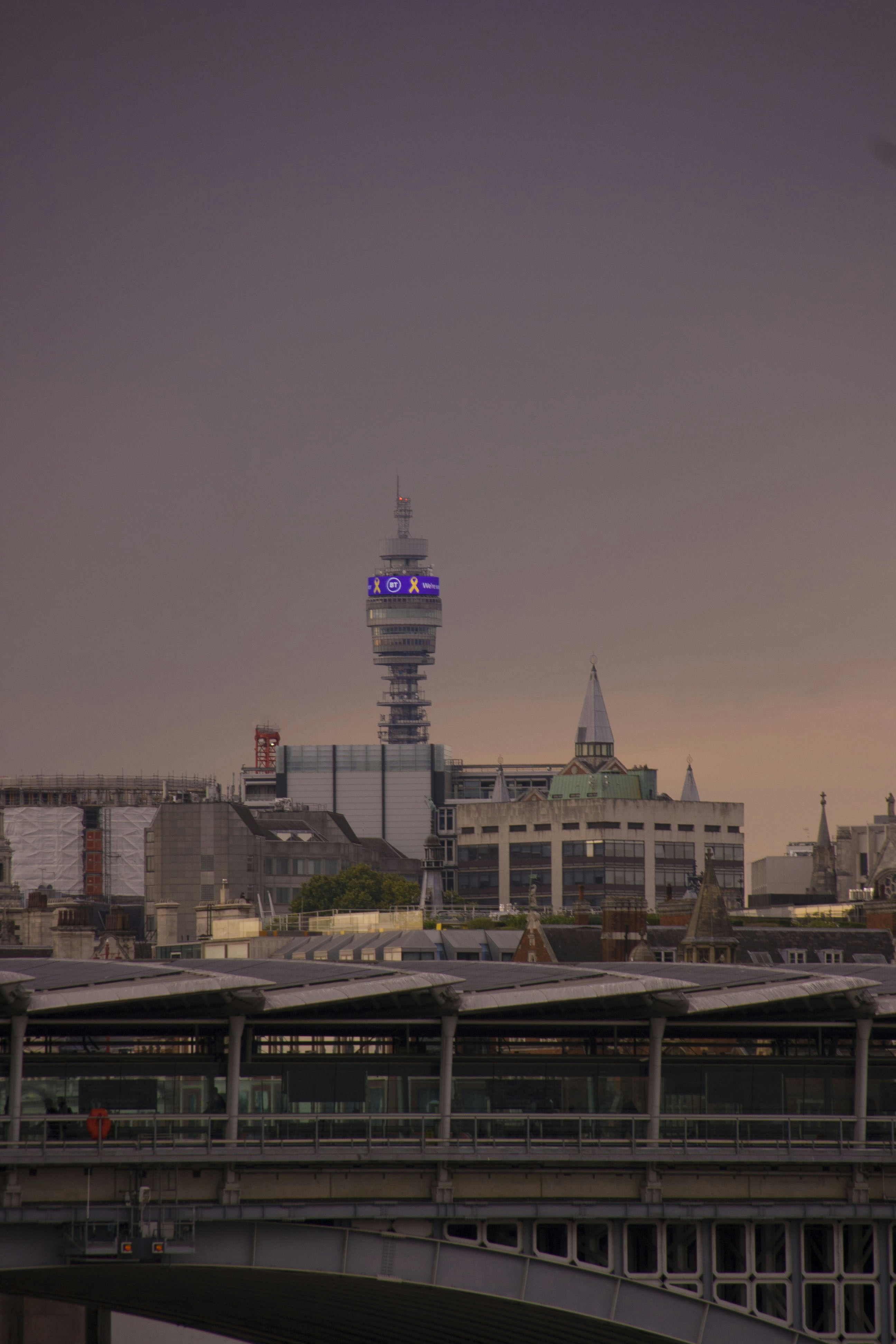 City Tower at Dusk: Neon Signage and Skyline Silhouette
