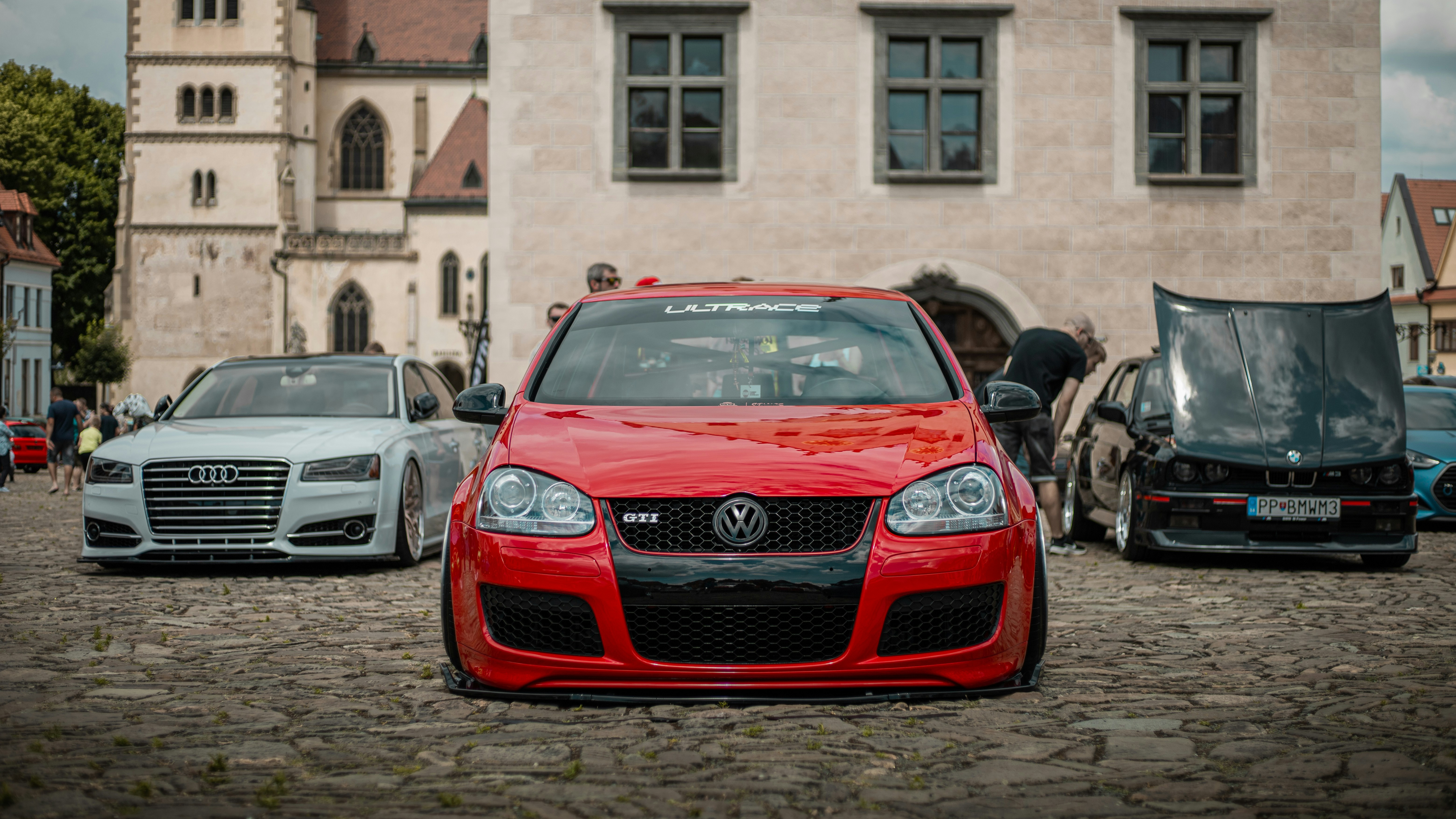 Crimson VW GTI Commands the Cobbled Square with Historic Backdrop