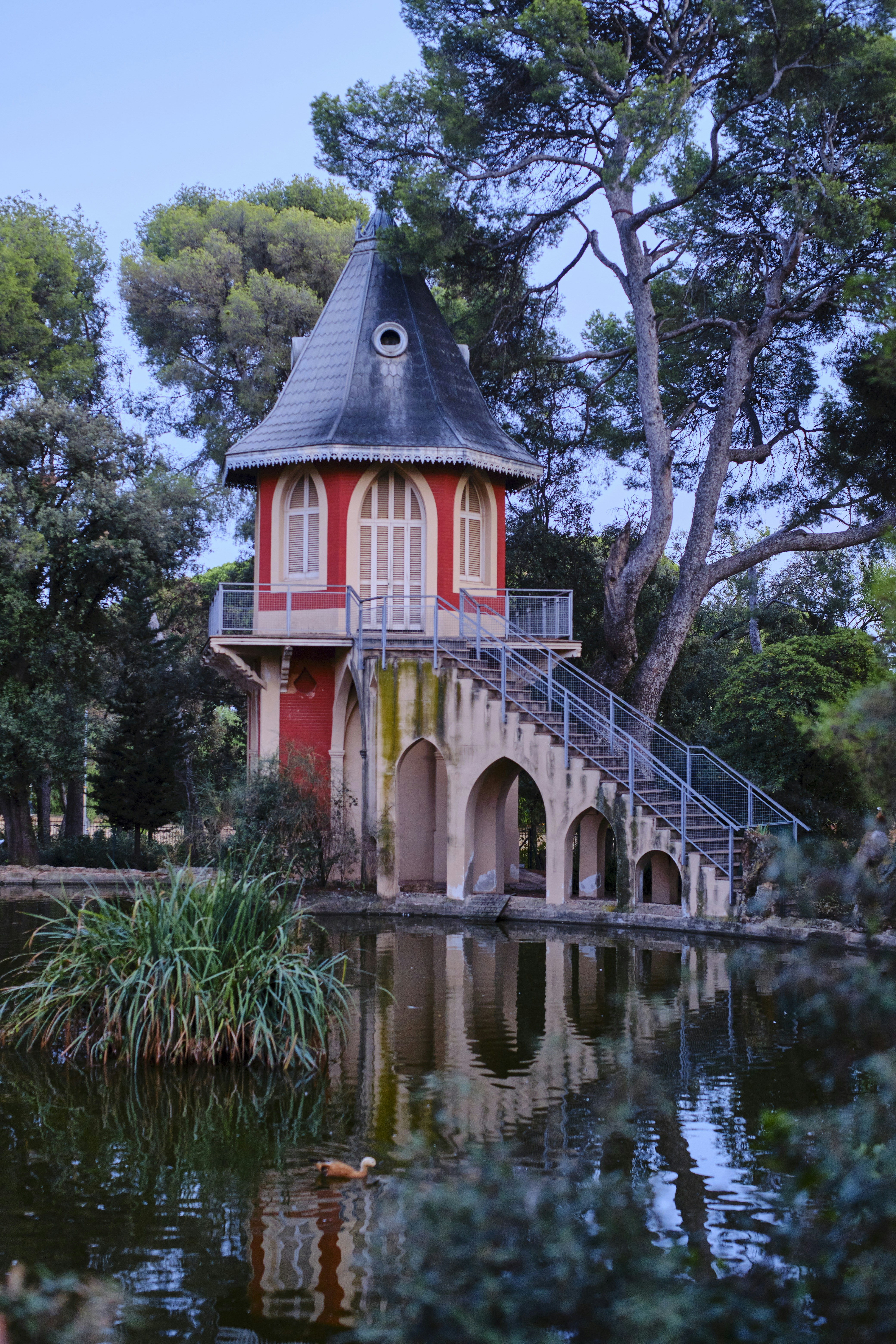 a red and white building on a bridge over water