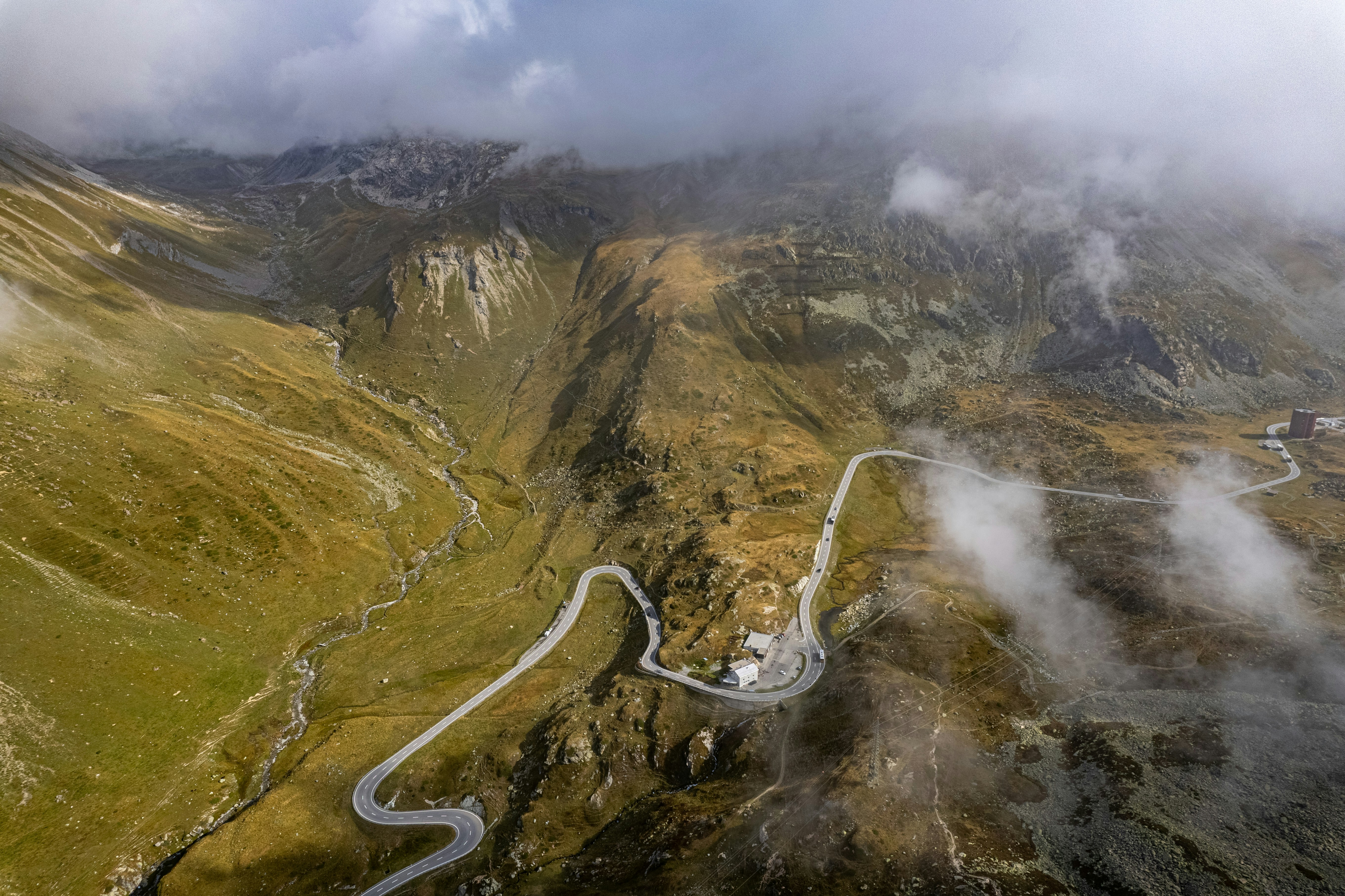 Serpentine ascent: Aerial twist through misty mountain switchbacks