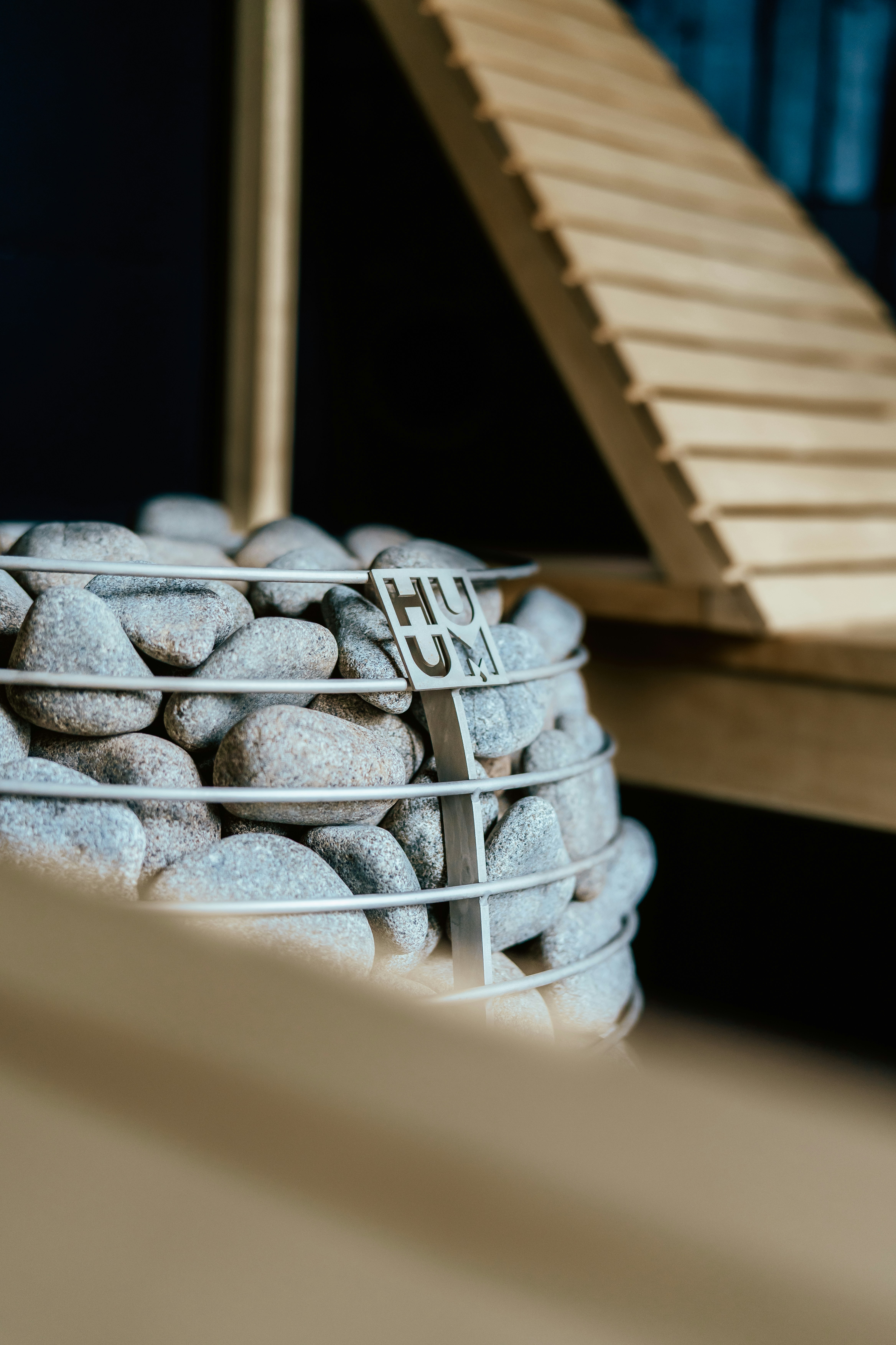 Harmonized Stones in a Metal Basket beside a Wooden Structure