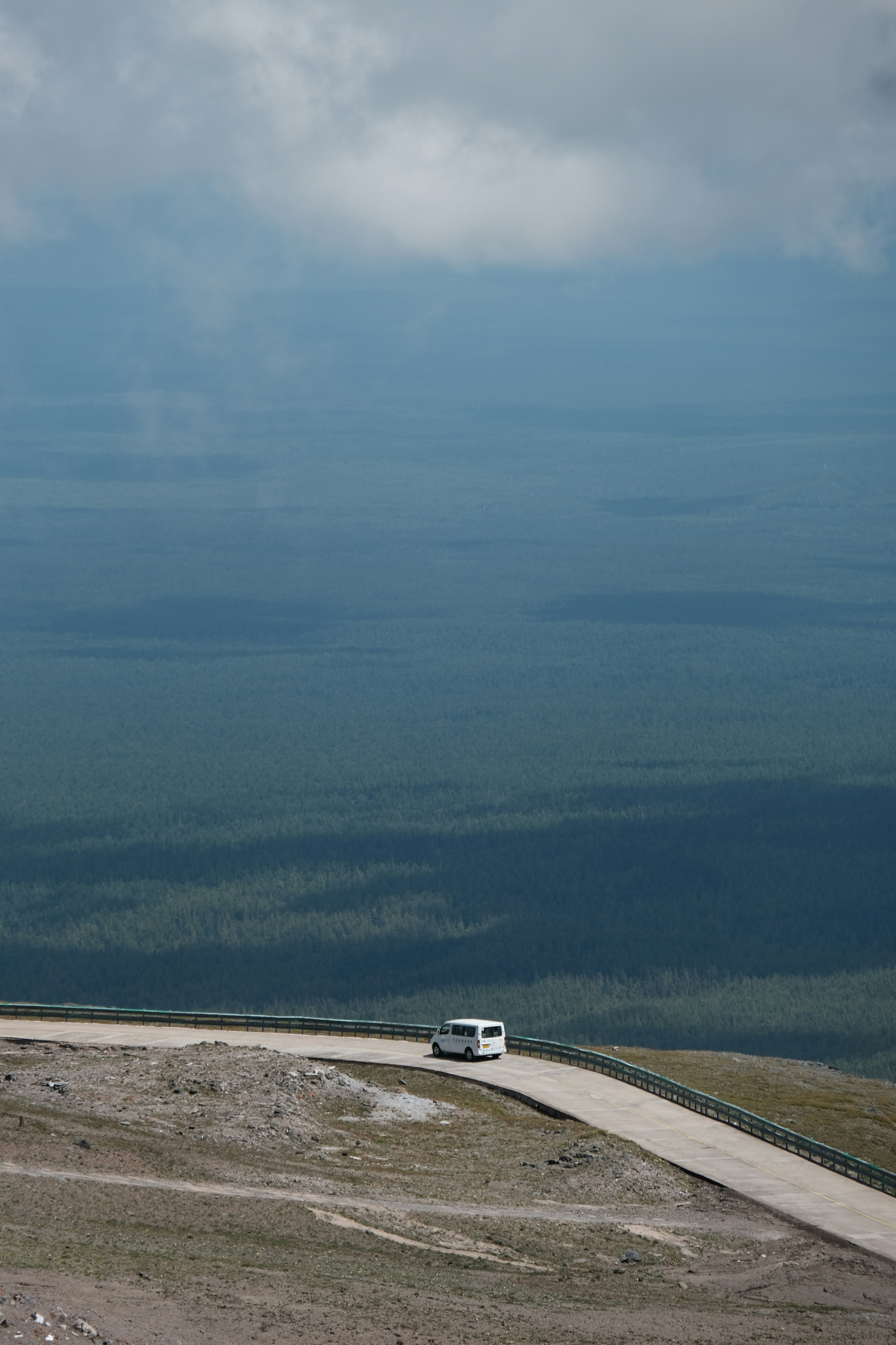 Car on a Serpentine Rim Above a Sea of Pines