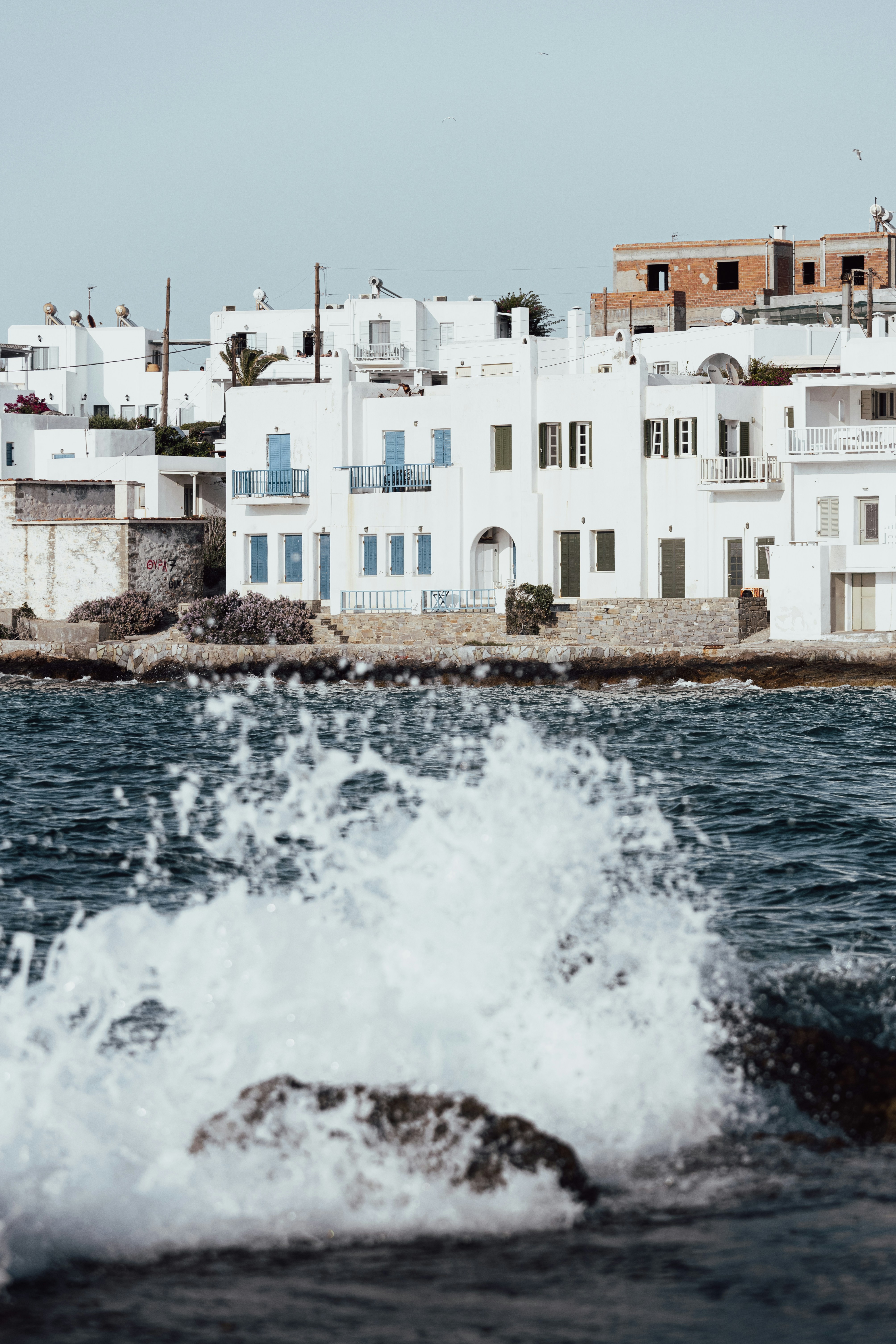 Whitewashed Waterfront: Waves Crown a Quiet Cycladic Lane