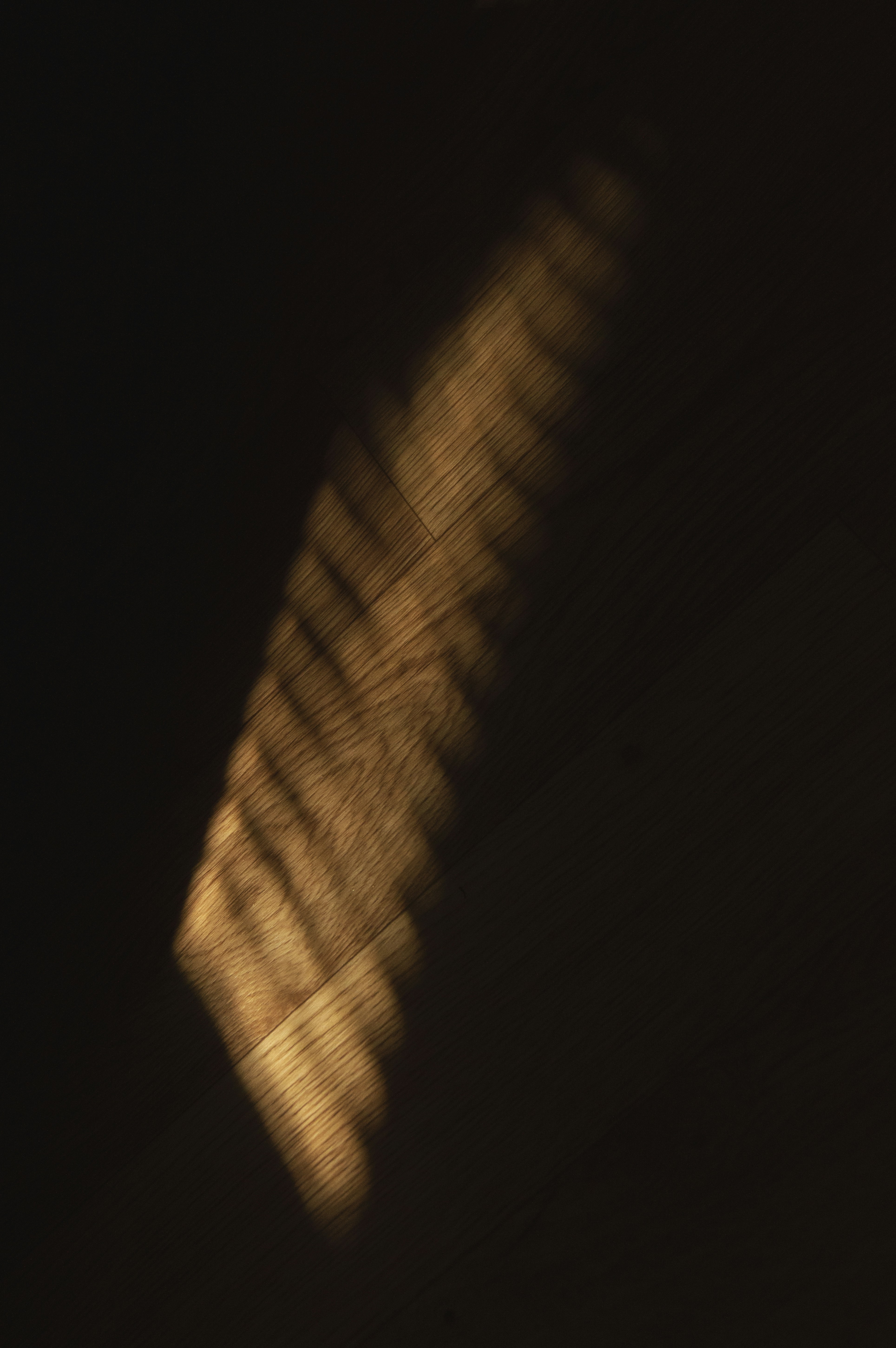 Soft shadows cast by light filtering through slats create a rhythmic pattern on the floor, emphasizing texture and contrast.
