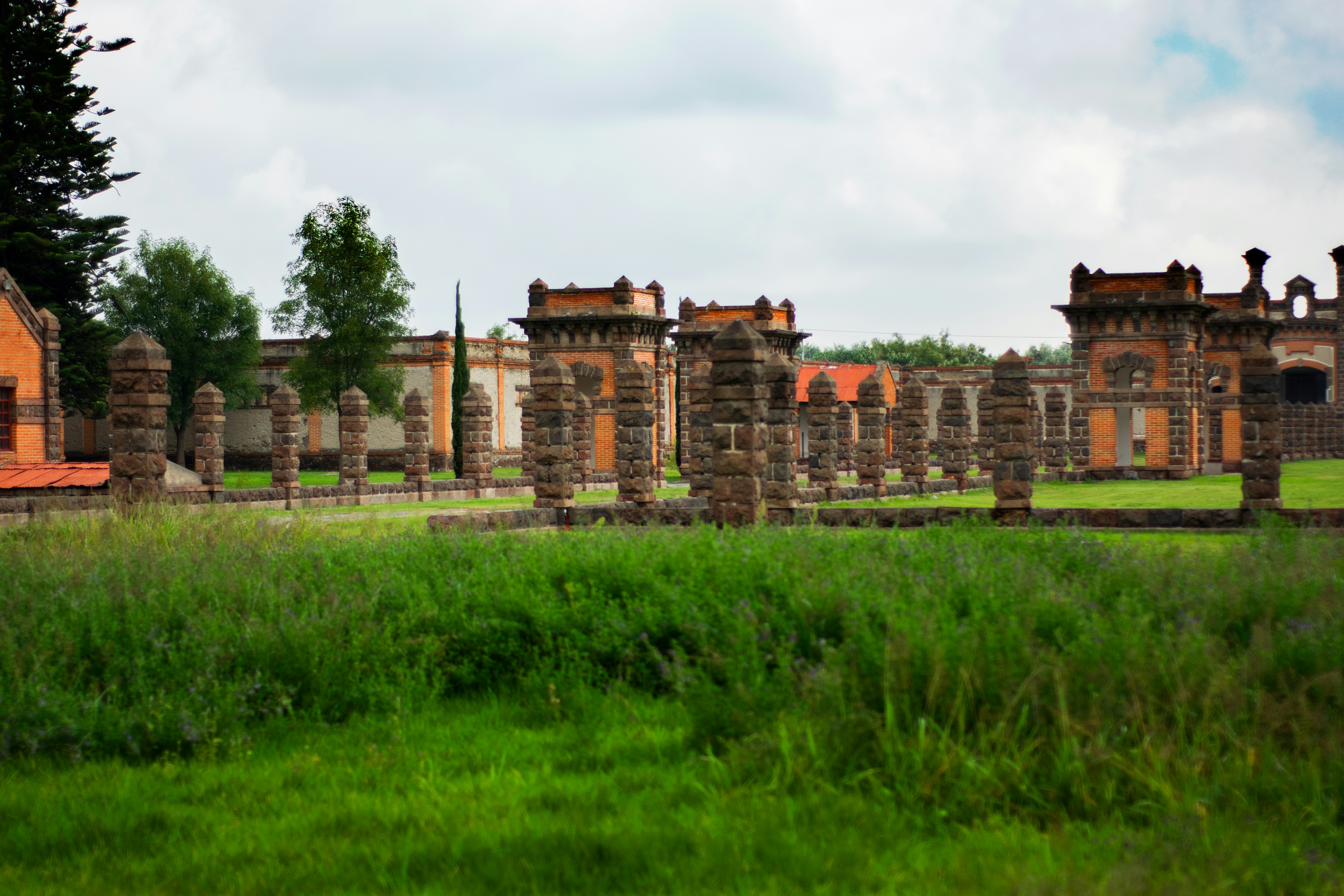 A large brick building with a grass field in front of it photo – Free ...