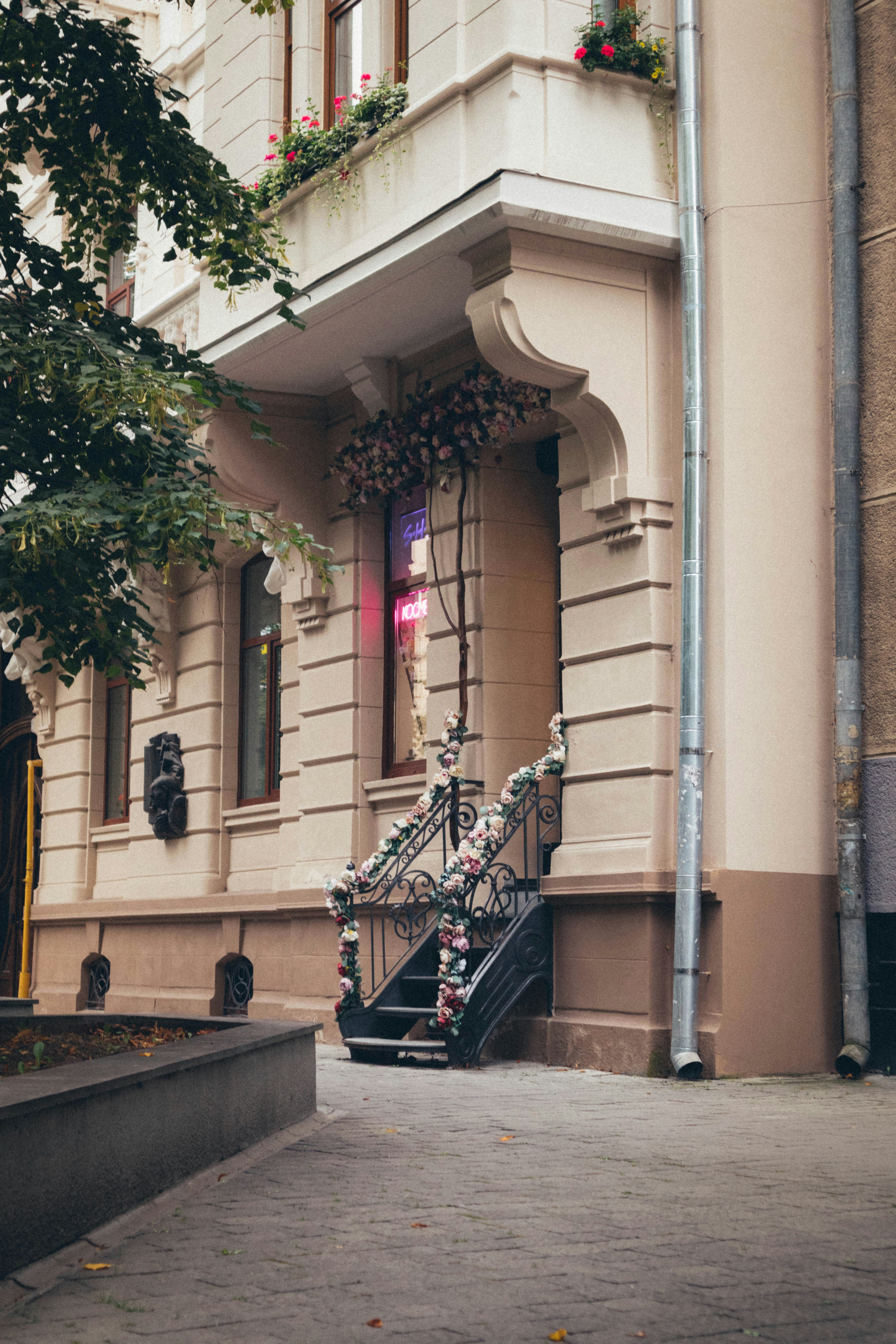 Flowered Staircase Beckons at a Cream-Colored Building Entrance