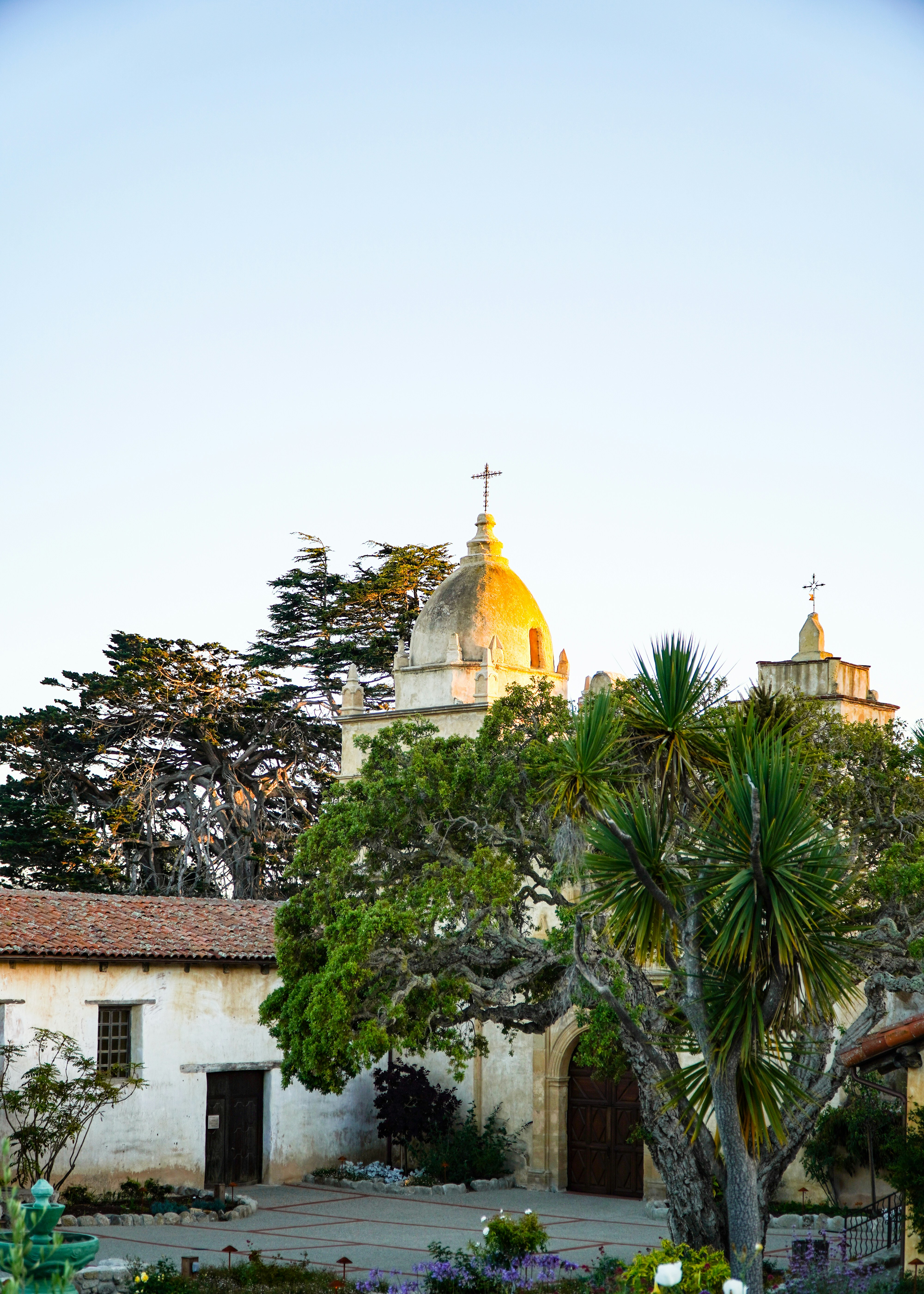 Dawn Light on a Mission Church: Domes Rise Over a Palm-Framed Courtyard