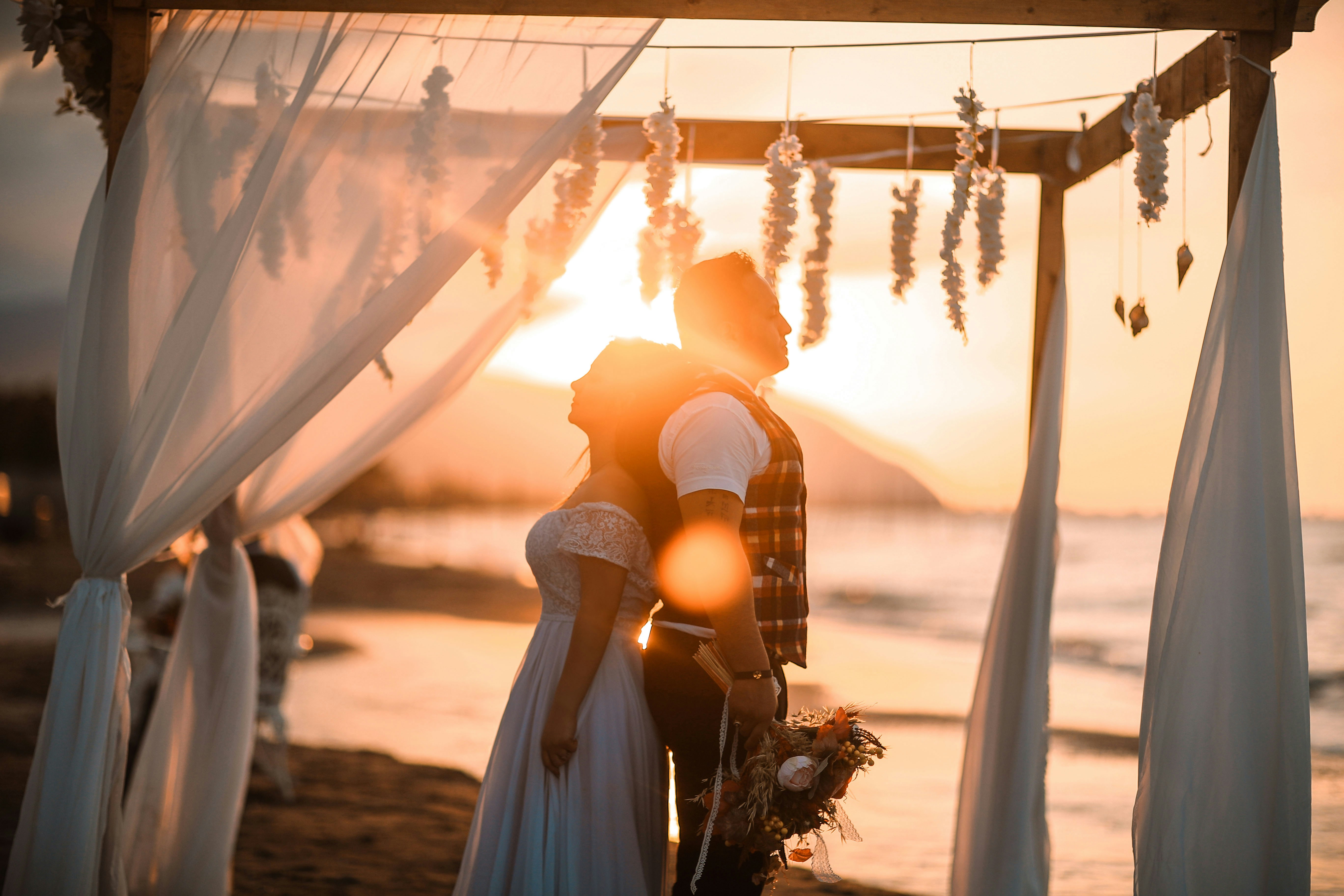 Sunset Vows: Silhouettes Beneath a Whispering Beach Canopy