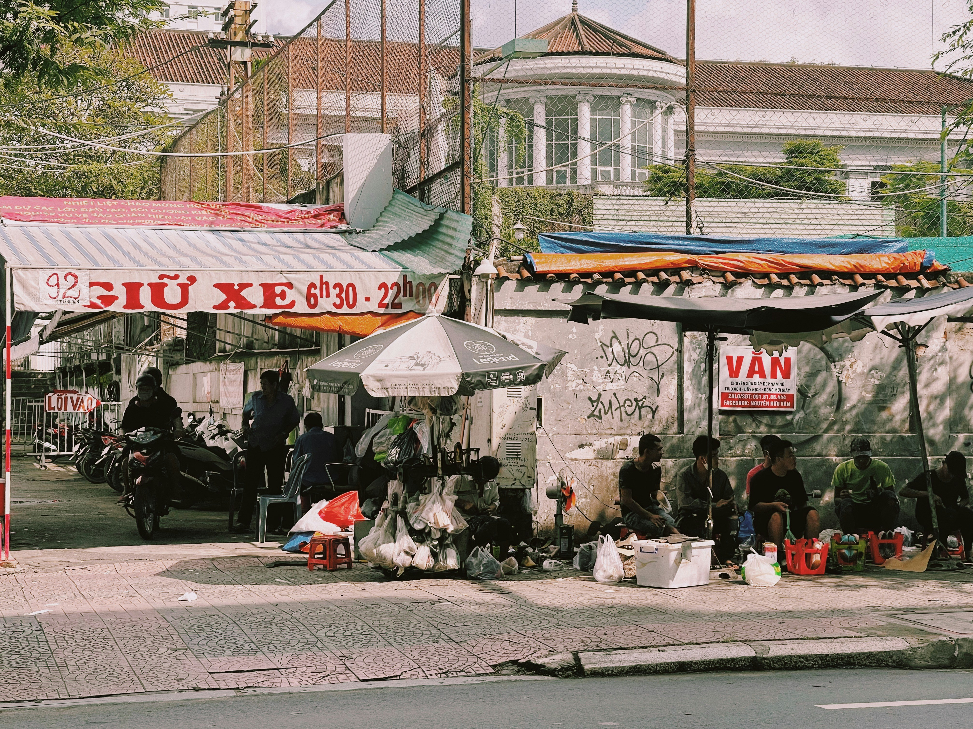 A group of individuals sit outside a small shop photo – Free Building ...