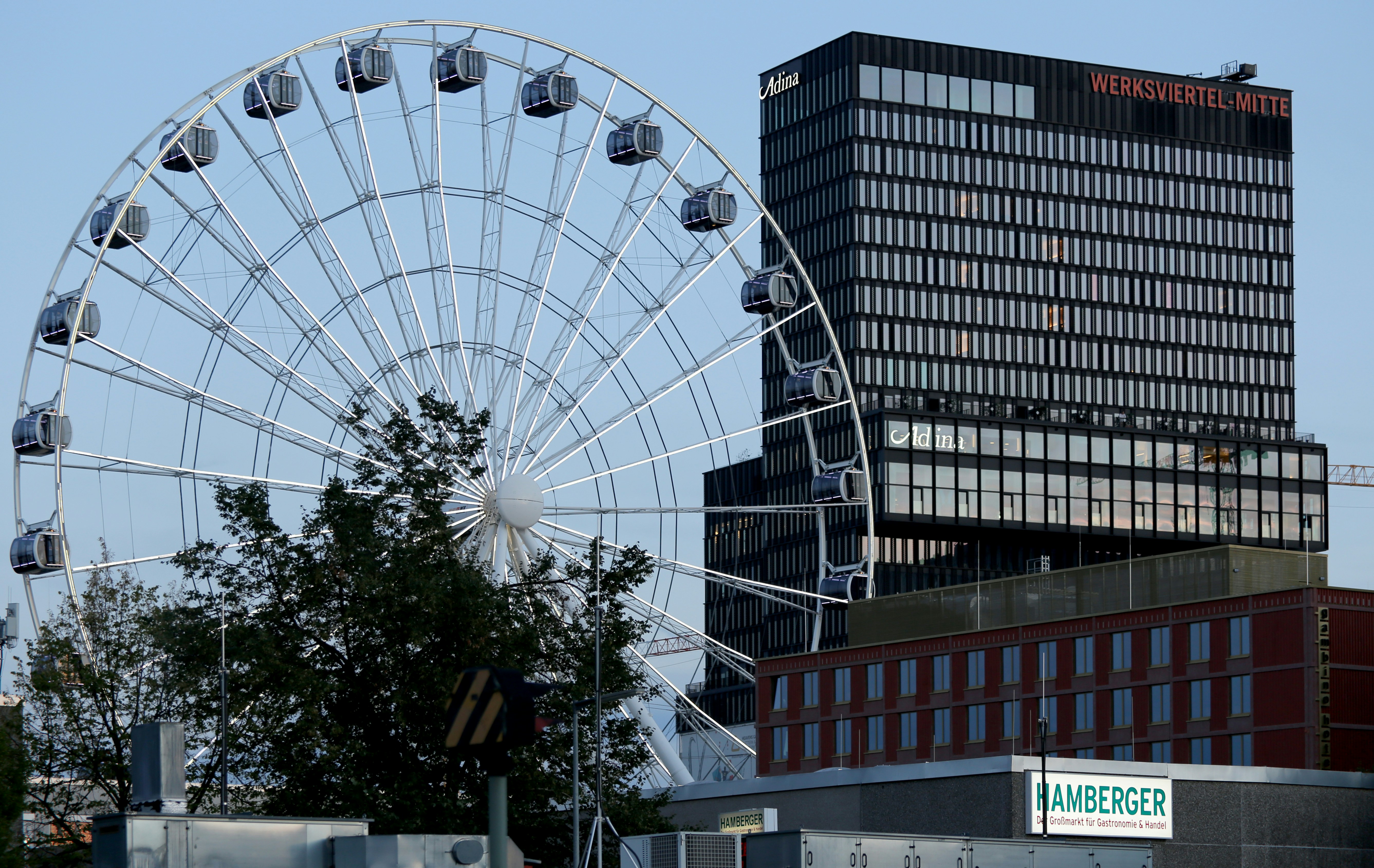 A ferris wheel next to a building photo – Free München Image on Unsplash