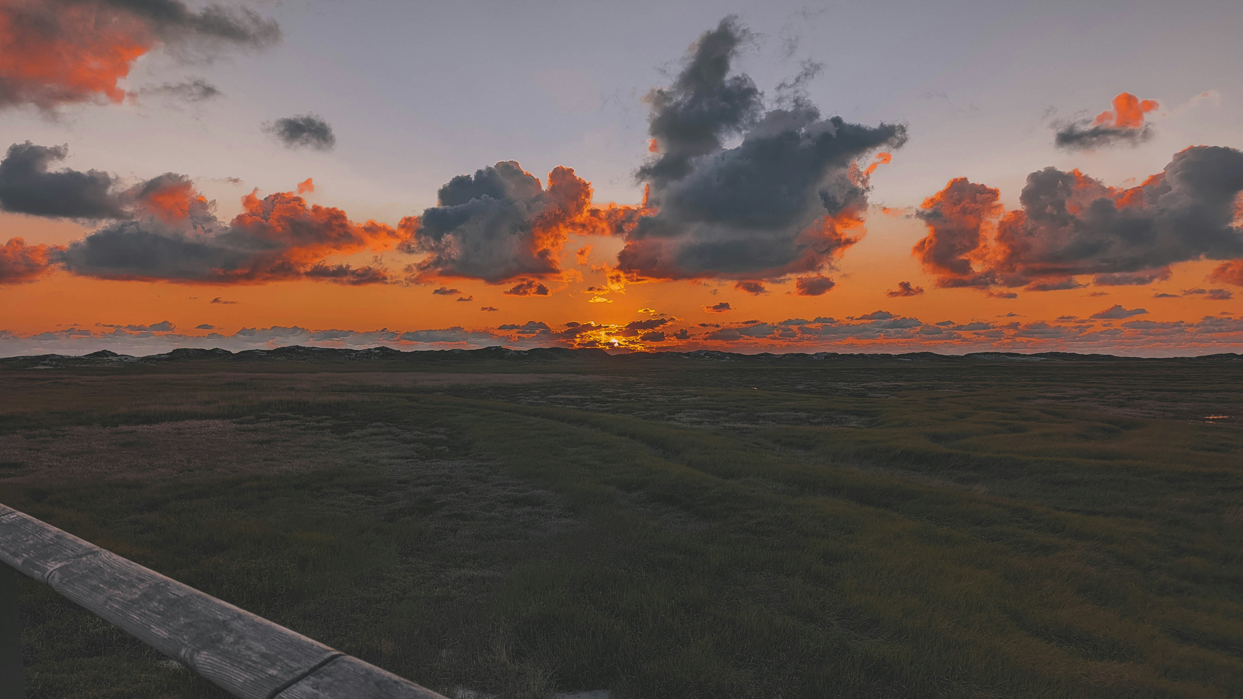 Sunset on the Prairie: A Weathered Railing Framing the Distant Horizon