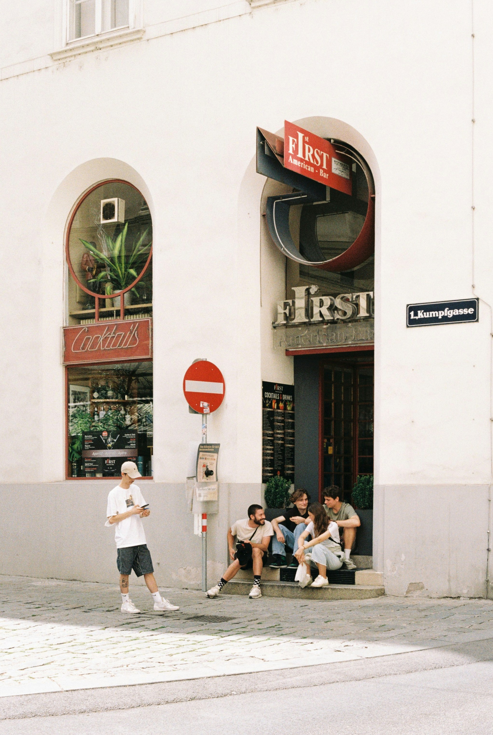 Street-side gathering in front of a café with curved archways